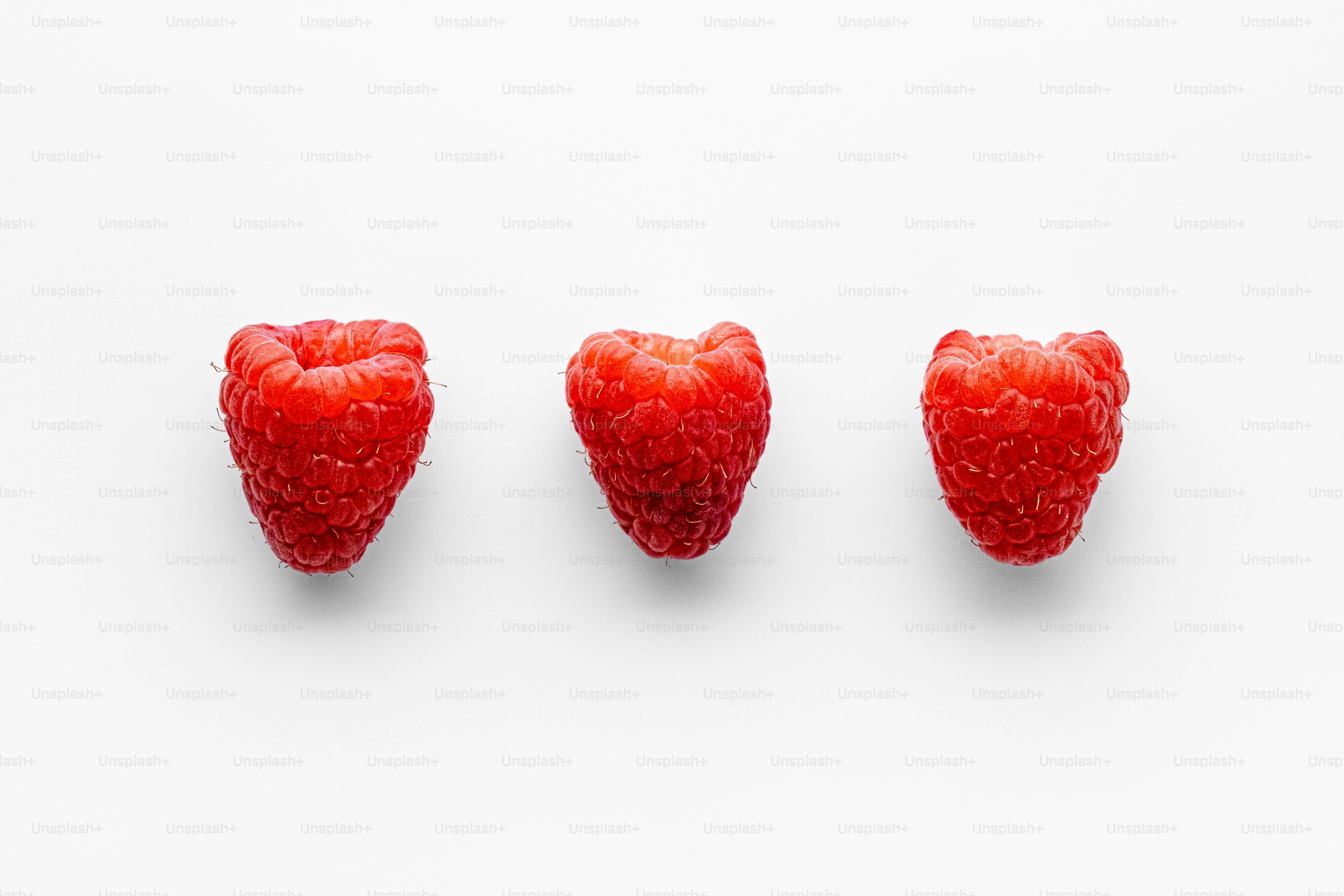 Four strawberries arranged in a row on a white background photo – Food ...