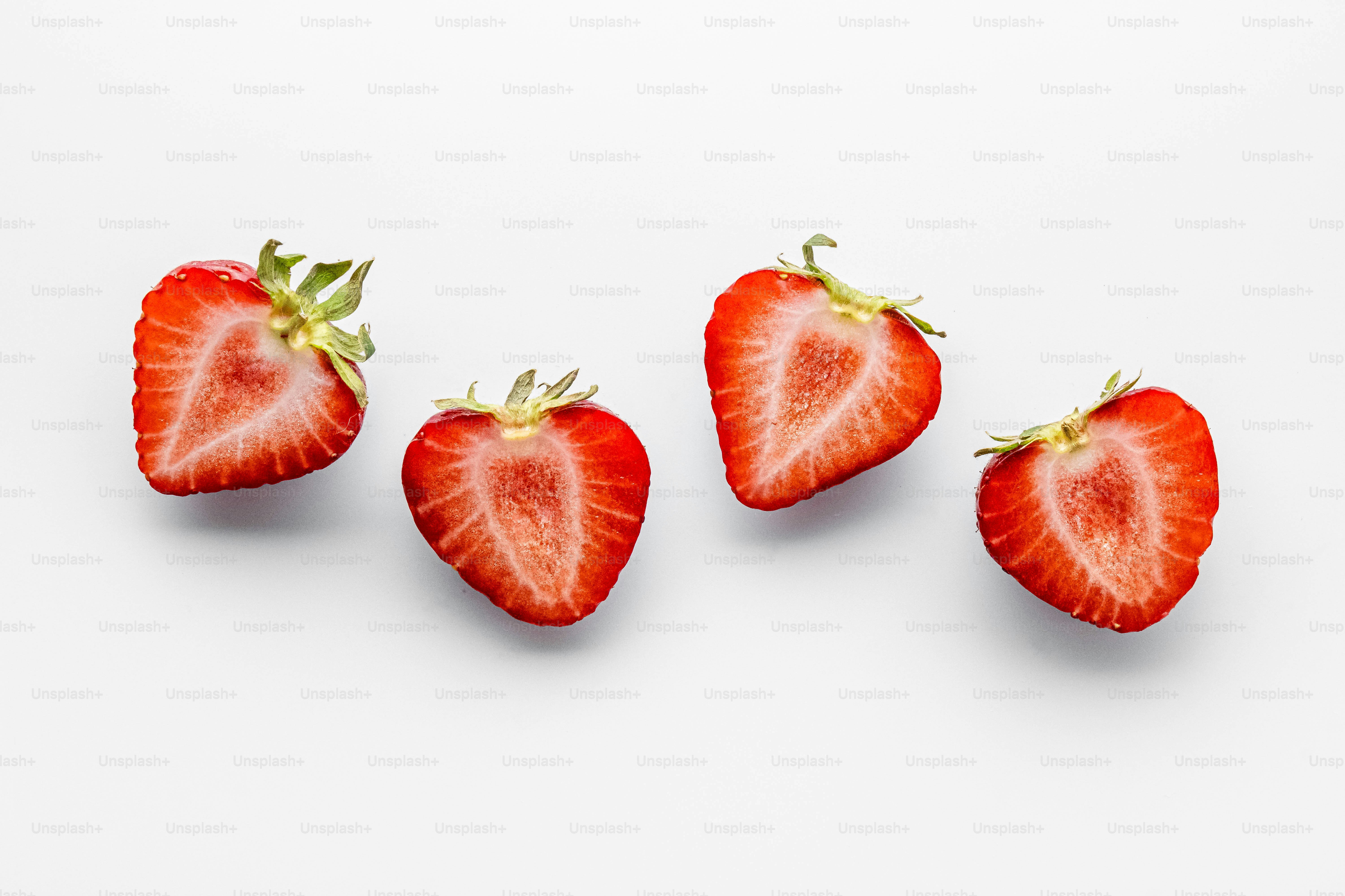 A group of four strawberries on a white background photo – Strawberry ...