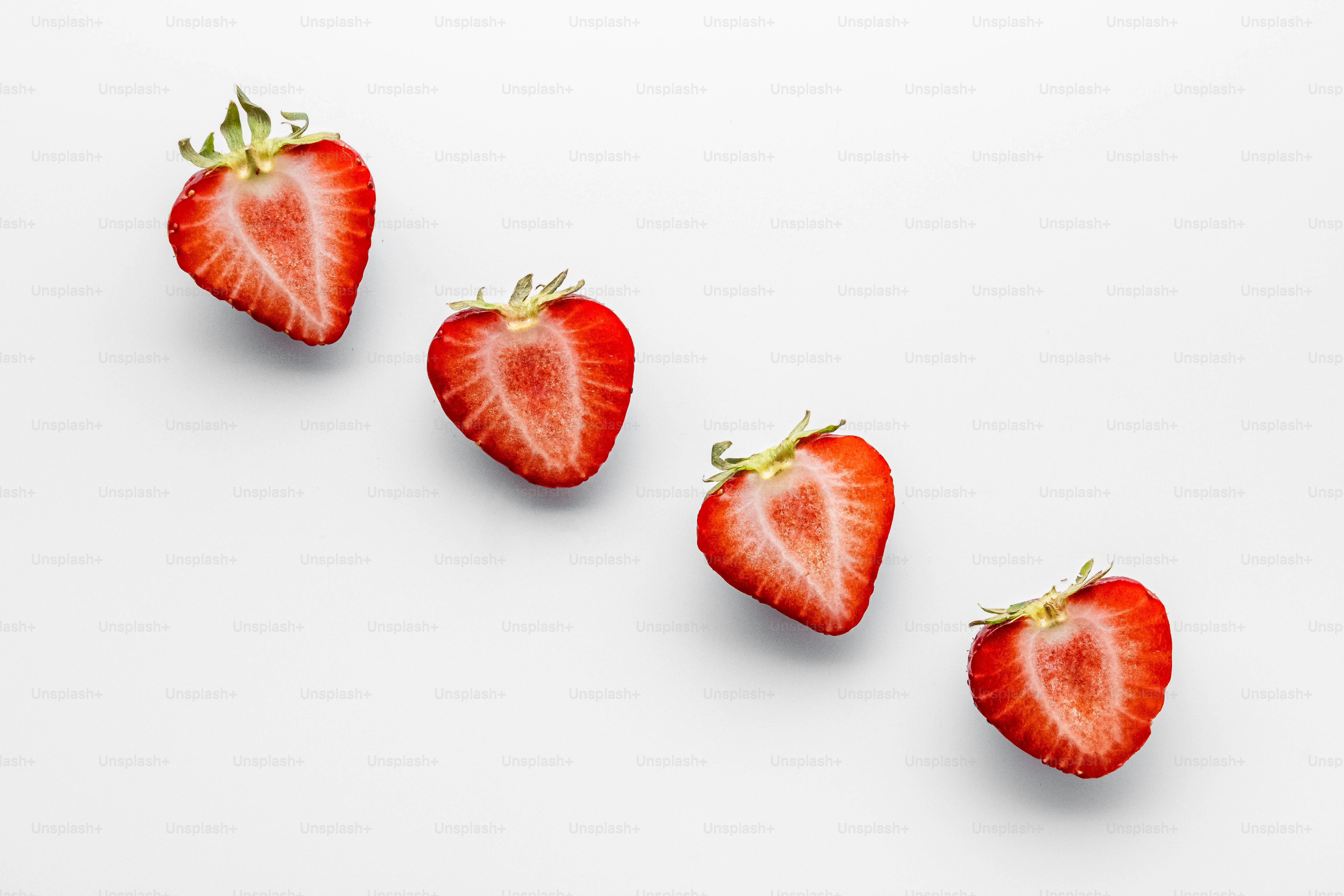 A group of four strawberries on a white background photo – Strawberry ...