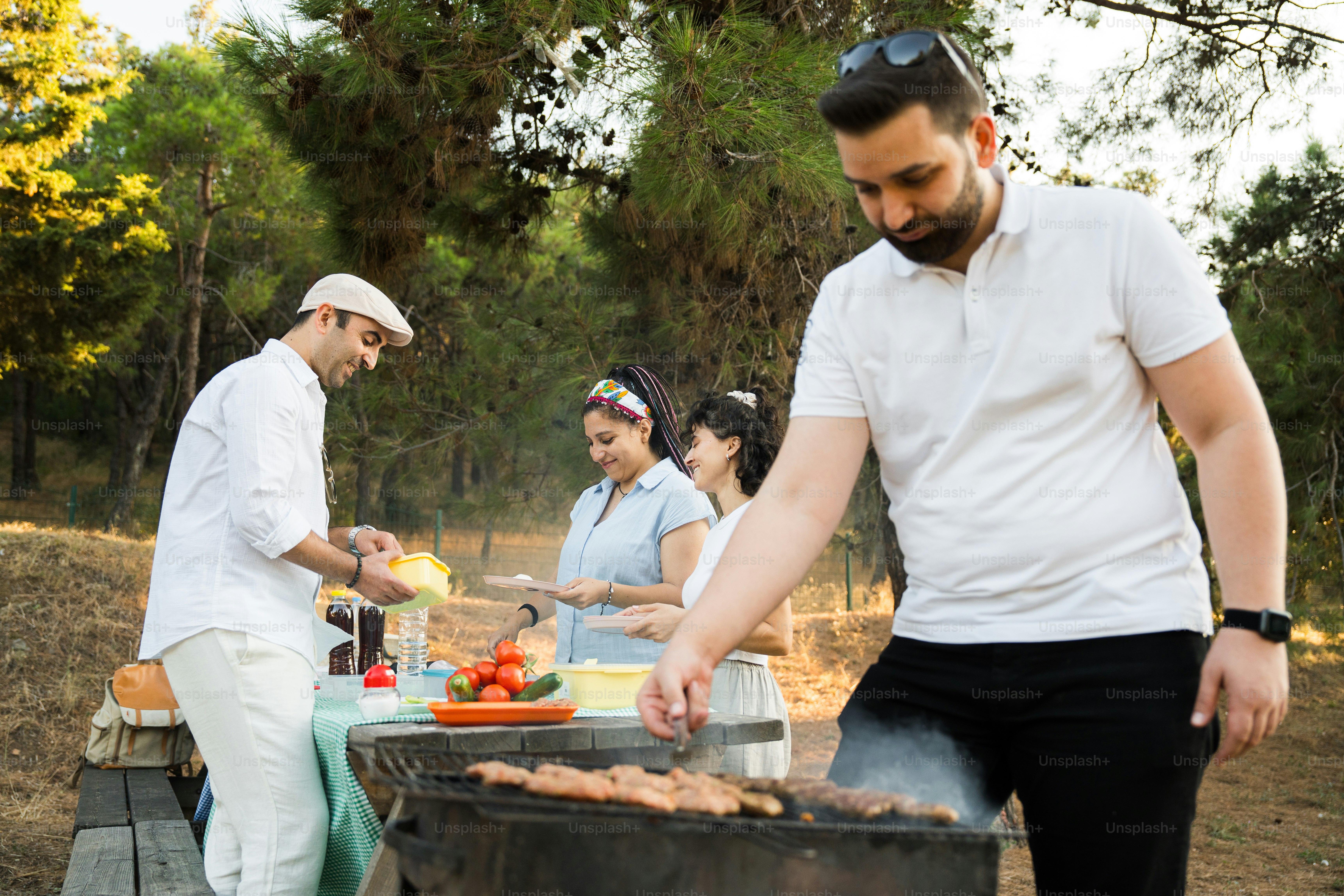 A group of people standing around a bbq grill photo – Family Image on ...
