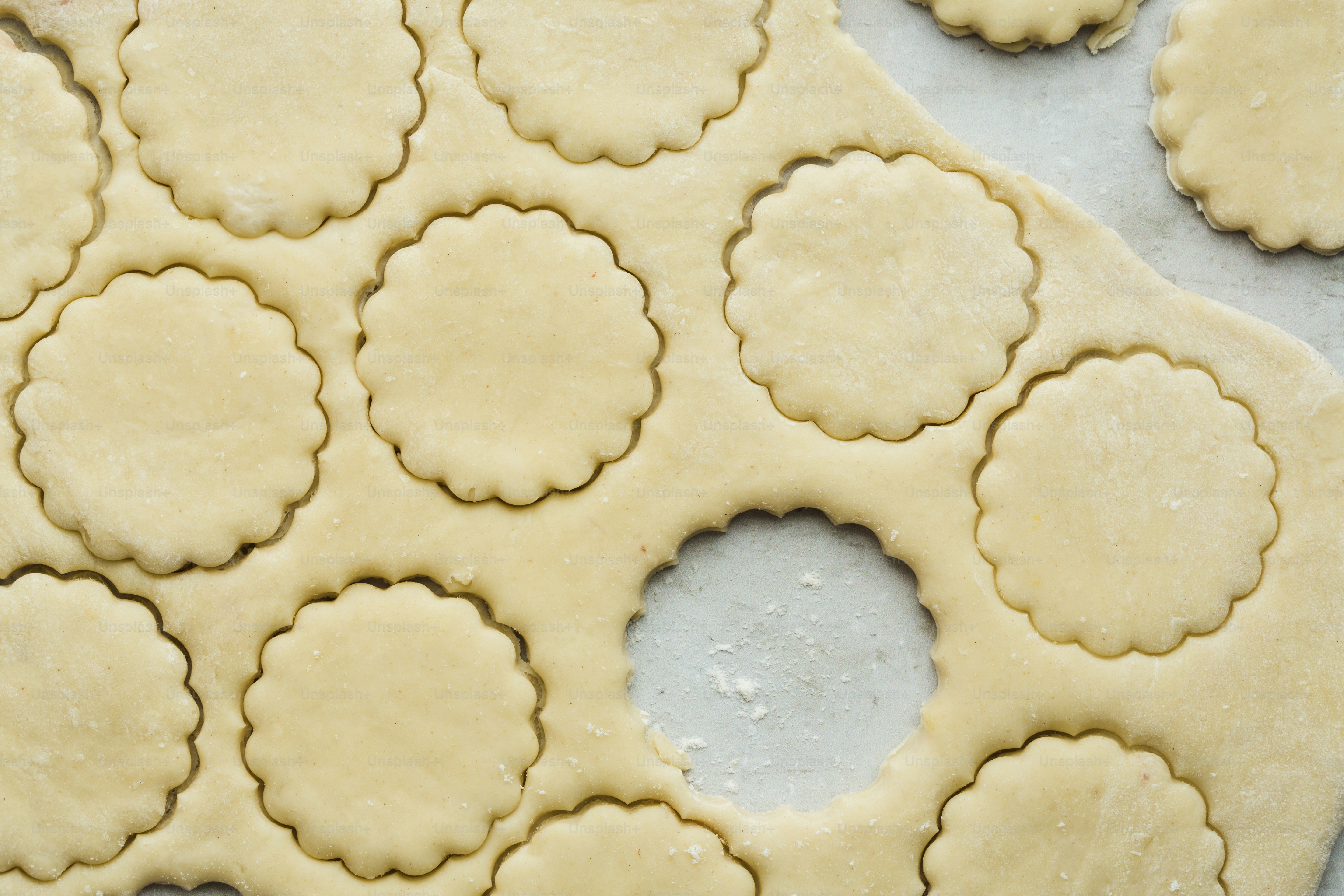 A bunch of cookies that are on a table photo – Cooking with dough Image ...