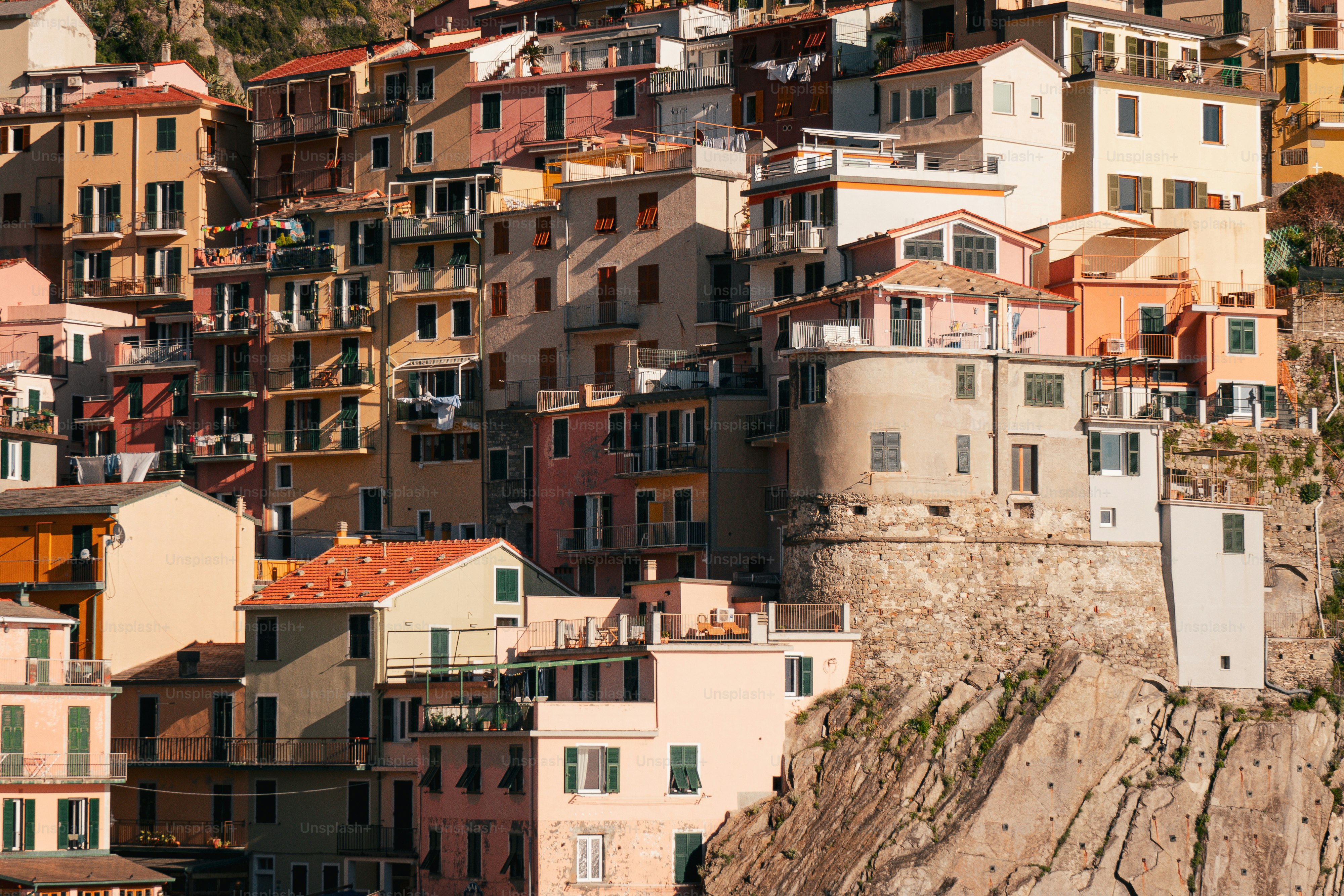 A group of buildings sitting on top of a cliff photo – Manarola marina ...