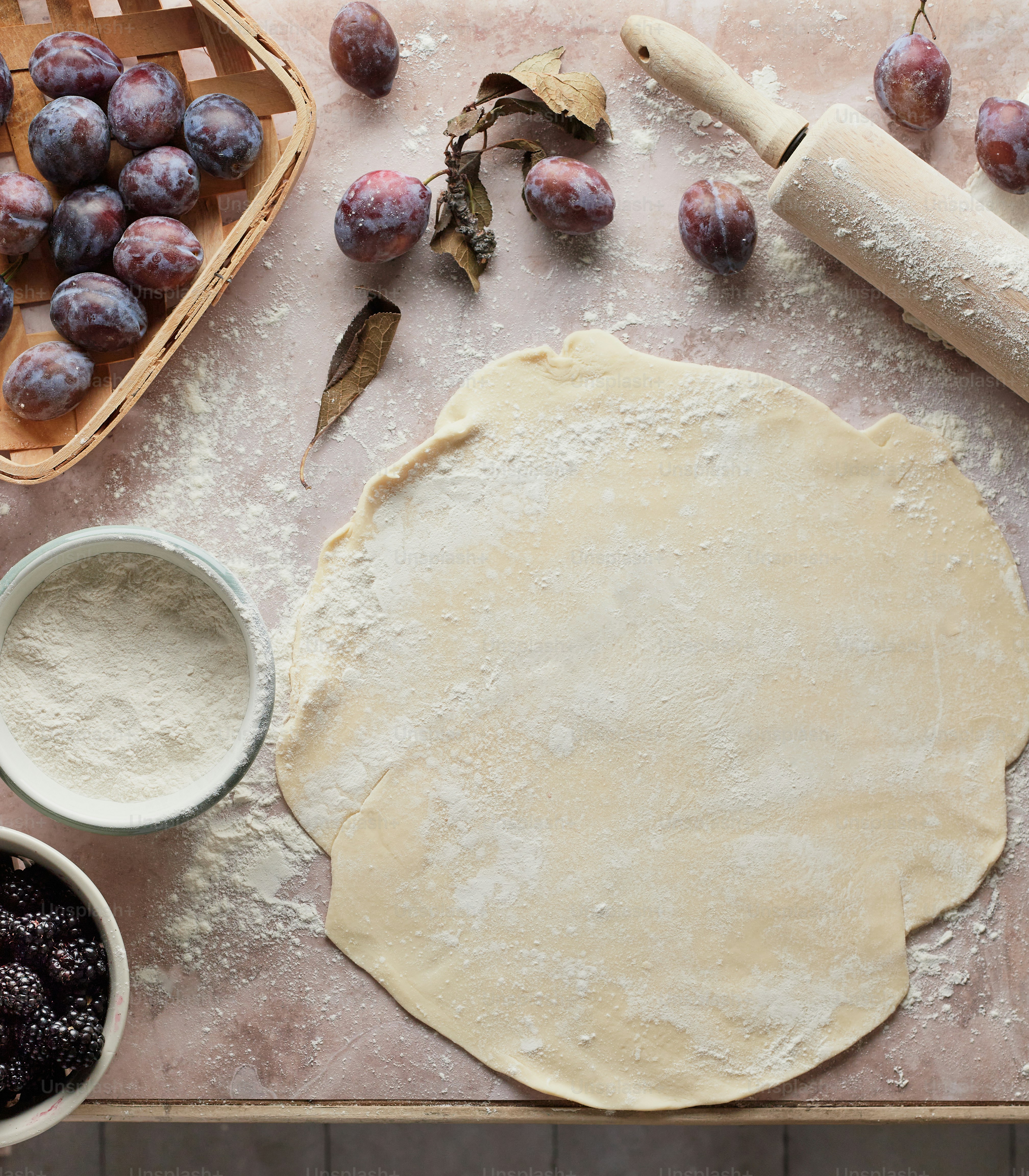 A table topped with dough, fruit and other ingredients photo – Food ...