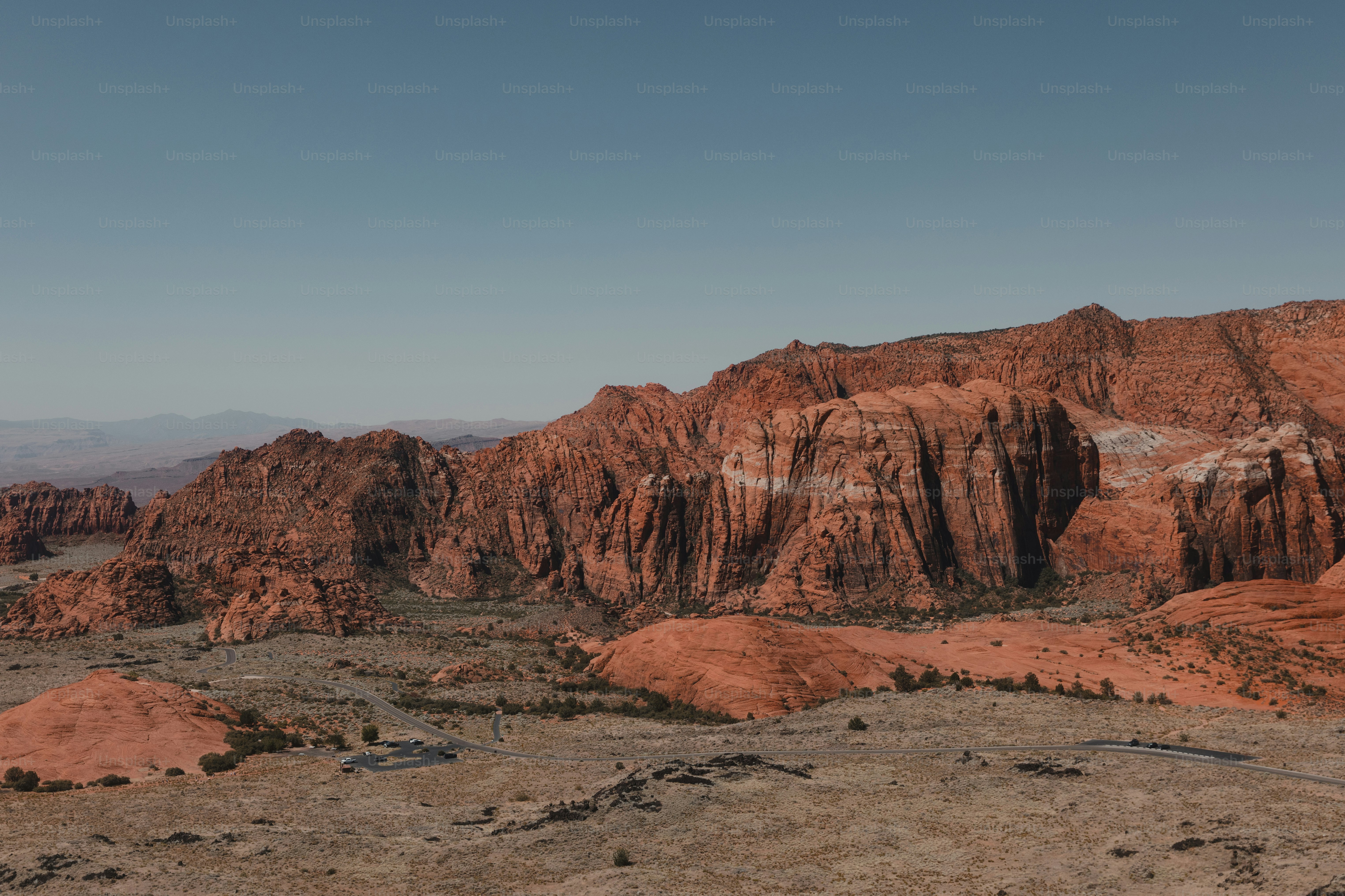A desert landscape with a mountain range in the background photo – Zion ...