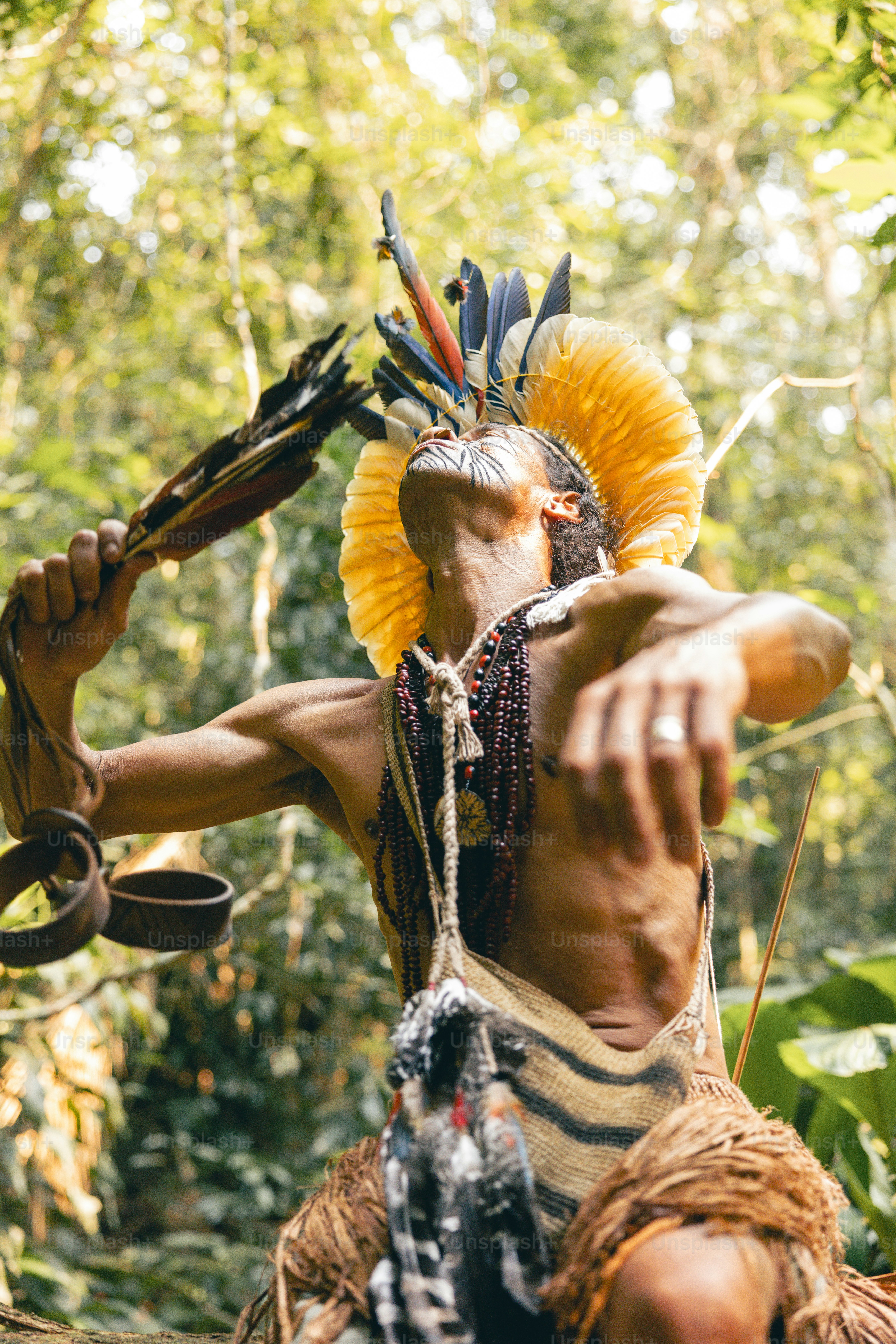A man in a native american headdress holding a gun photo – Native Image ...