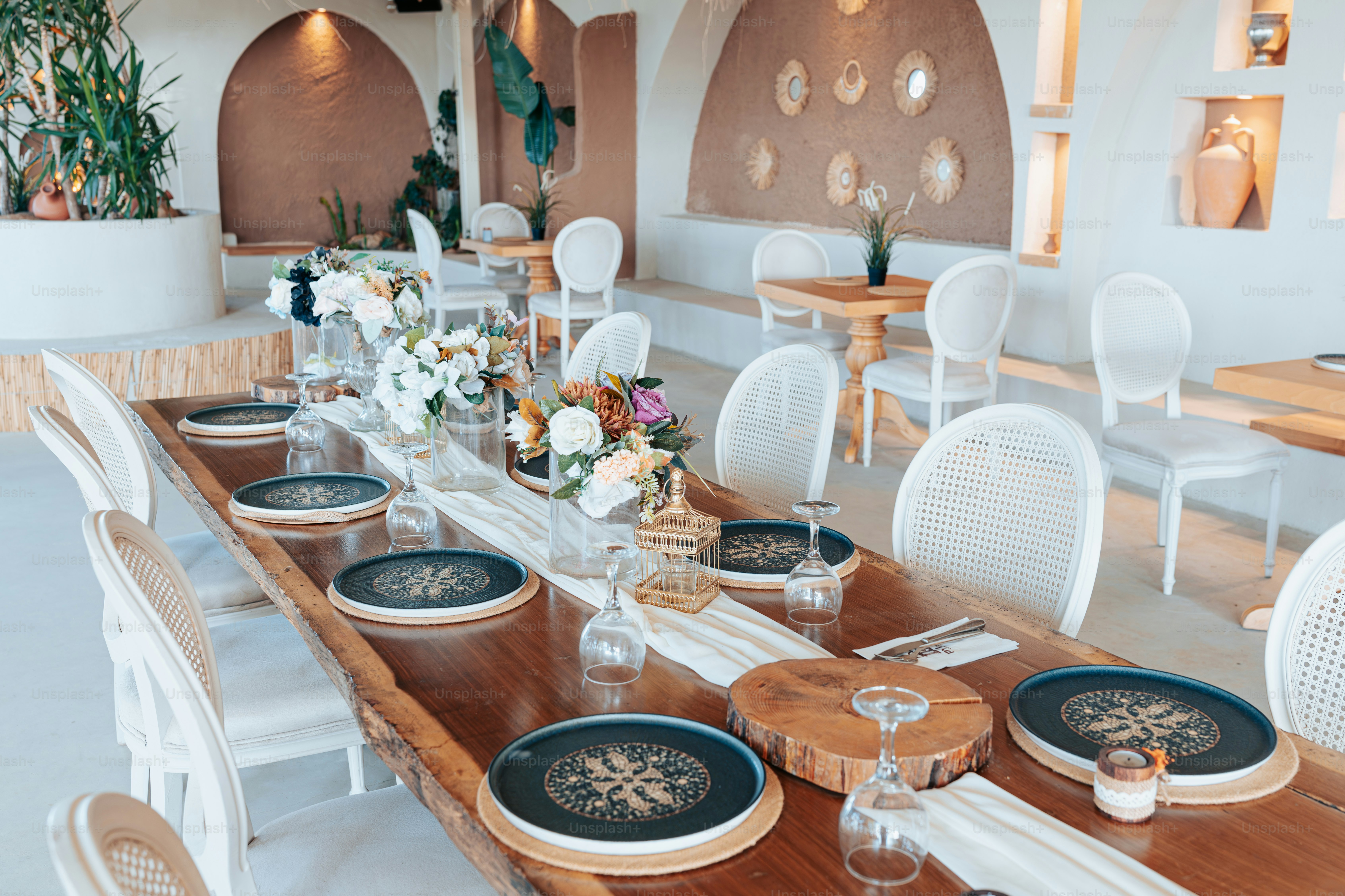A dining room with a long wooden table and white chairs photo ...