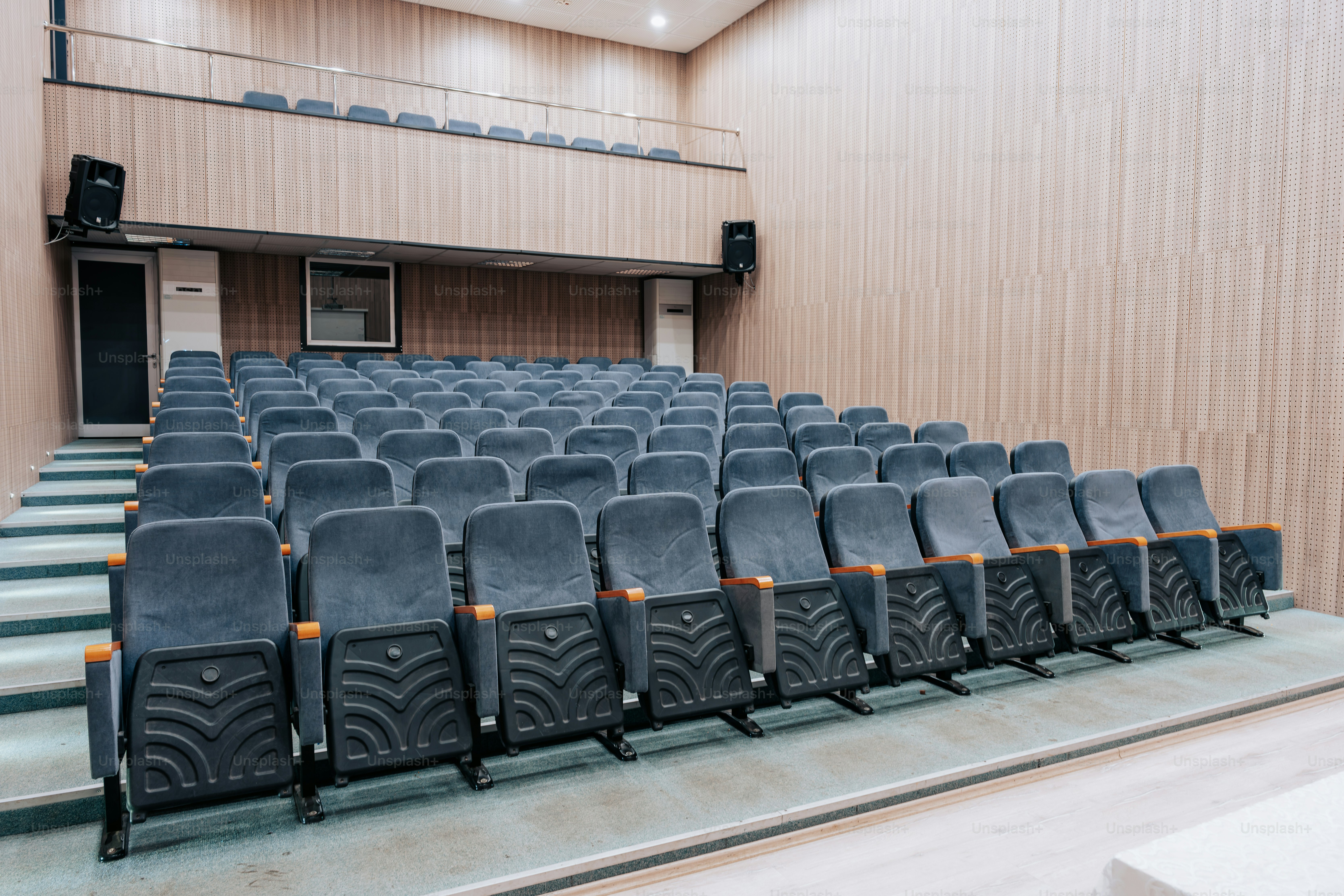 A large auditorium with rows of chairs and a projector screen photo ...