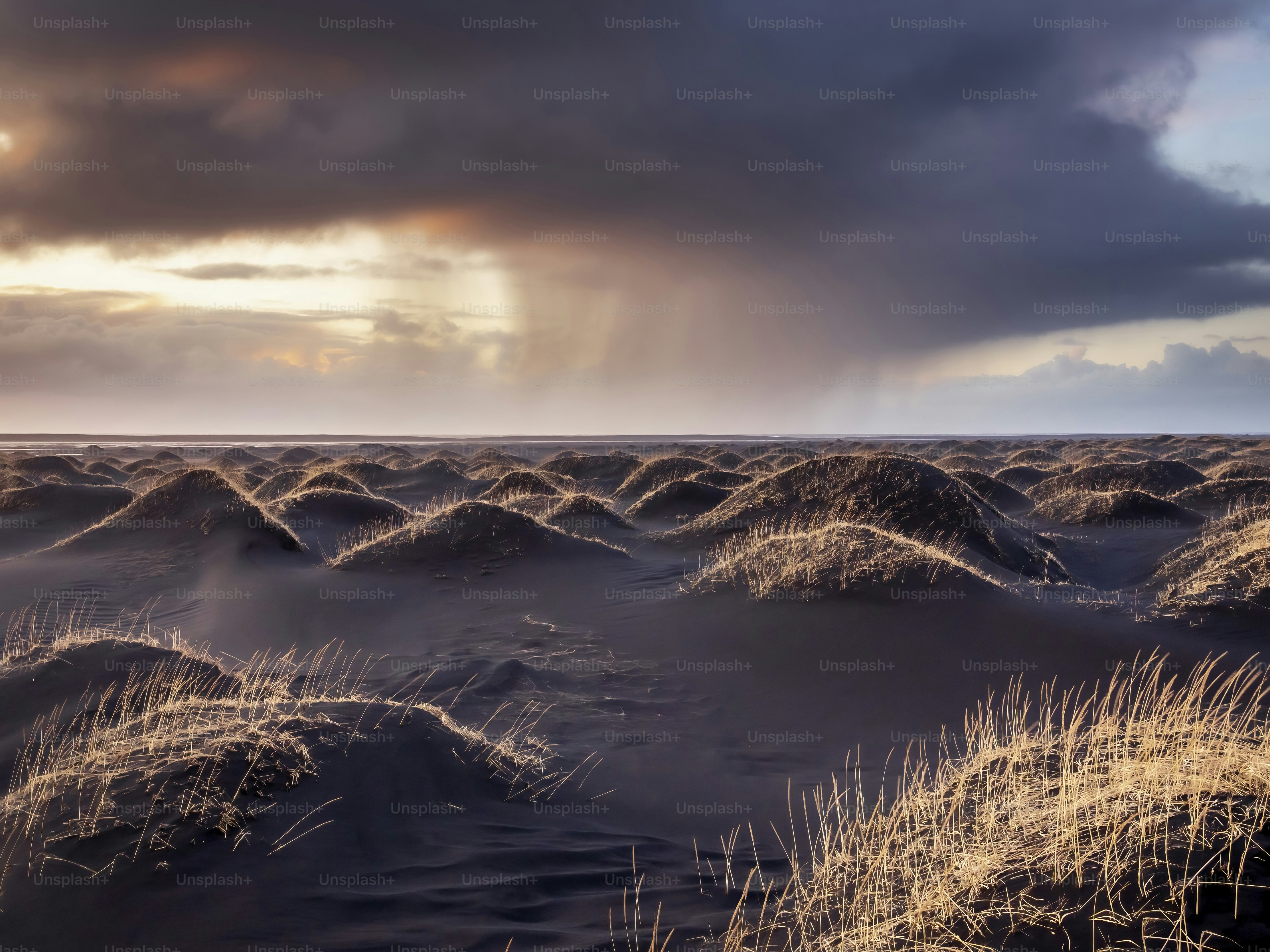 A cloudy sky is seen over a vast expanse of sand dunes photo – Dunes ...