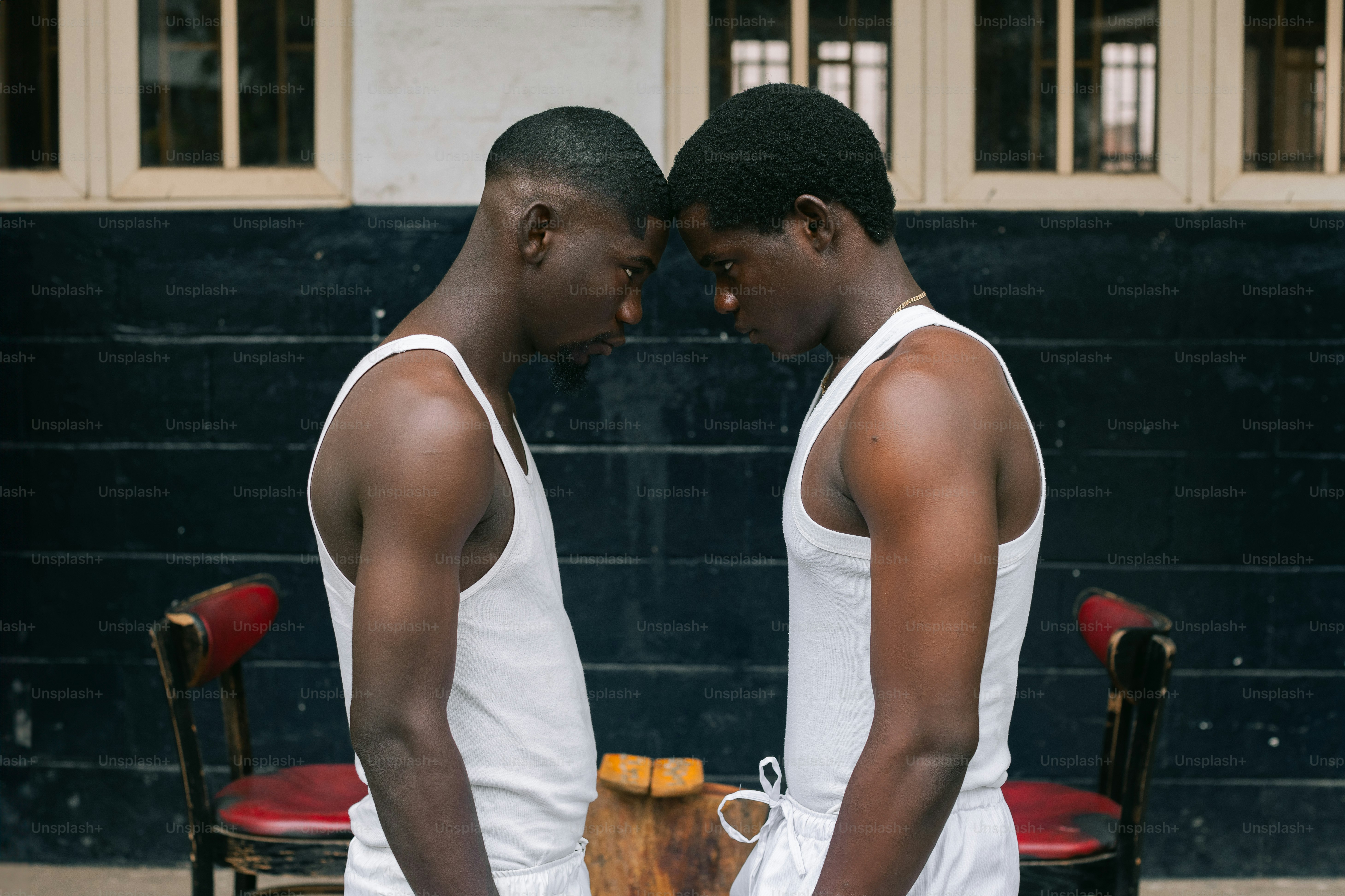Two men standing next to each other in front of a building photo – Ayo ...