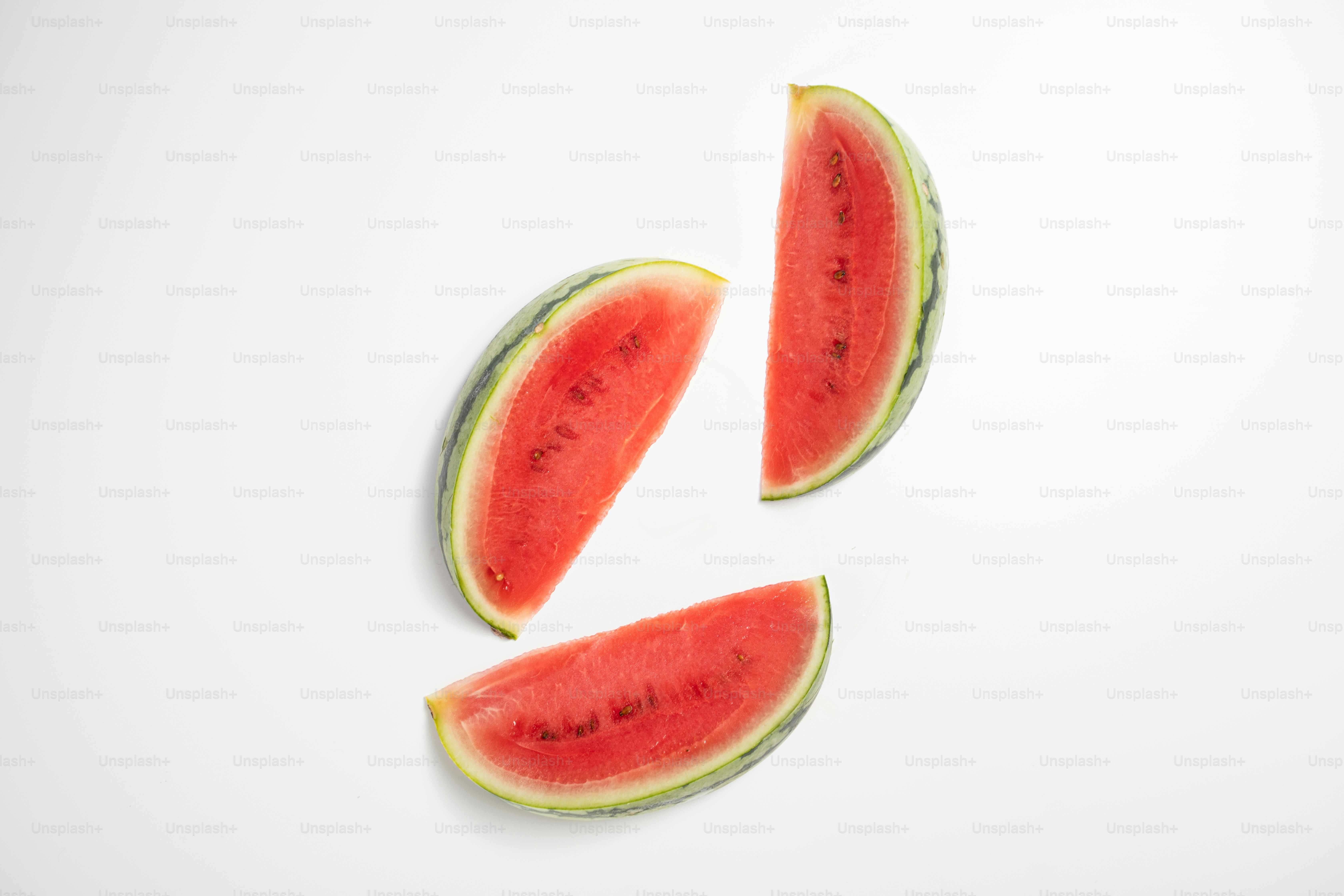 A group of slices of watermelon on a white surface photo – Summer food ...