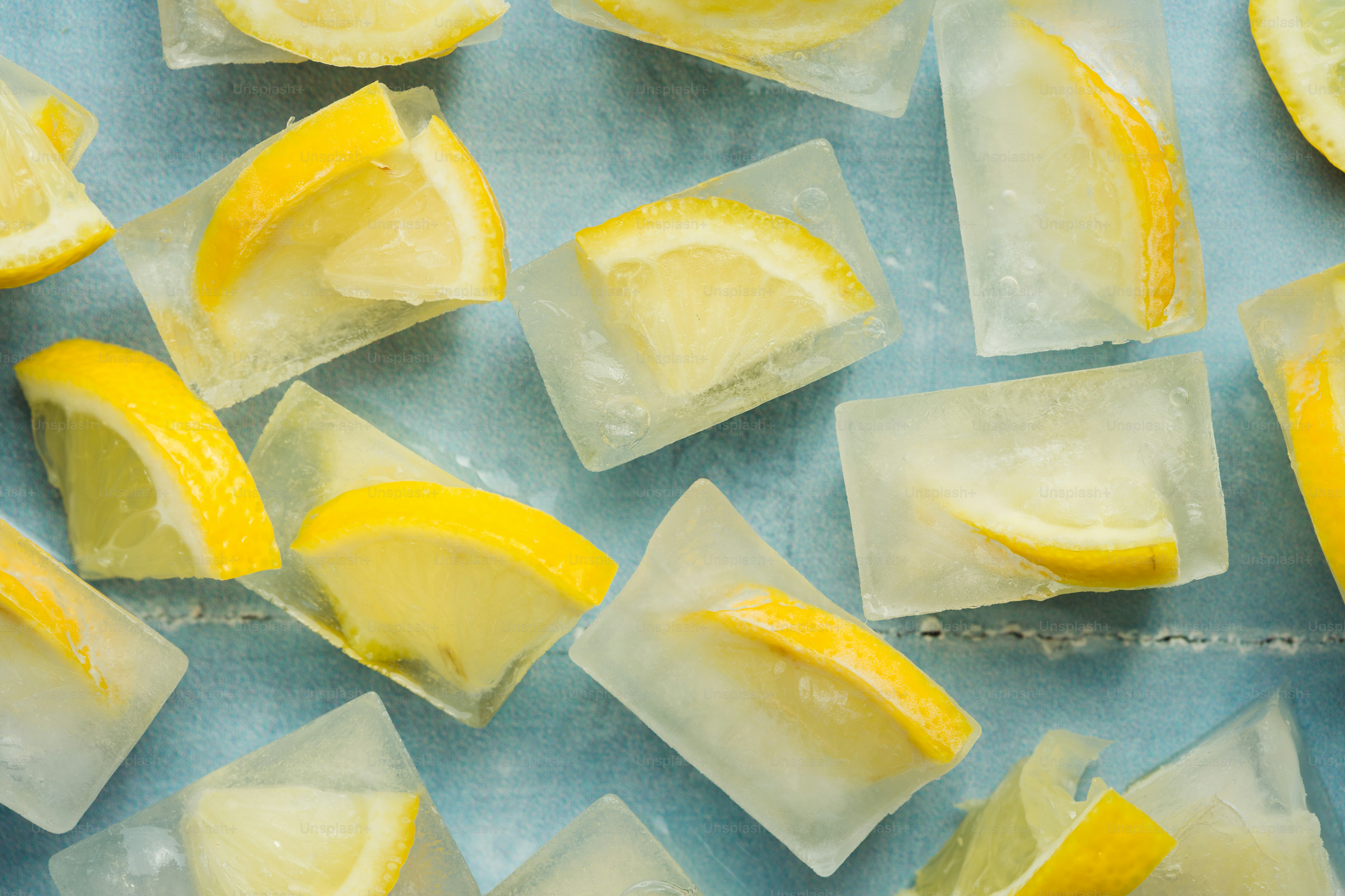 Sliced lemons and ice cubes on a blue surface photo – Waste Image on ...