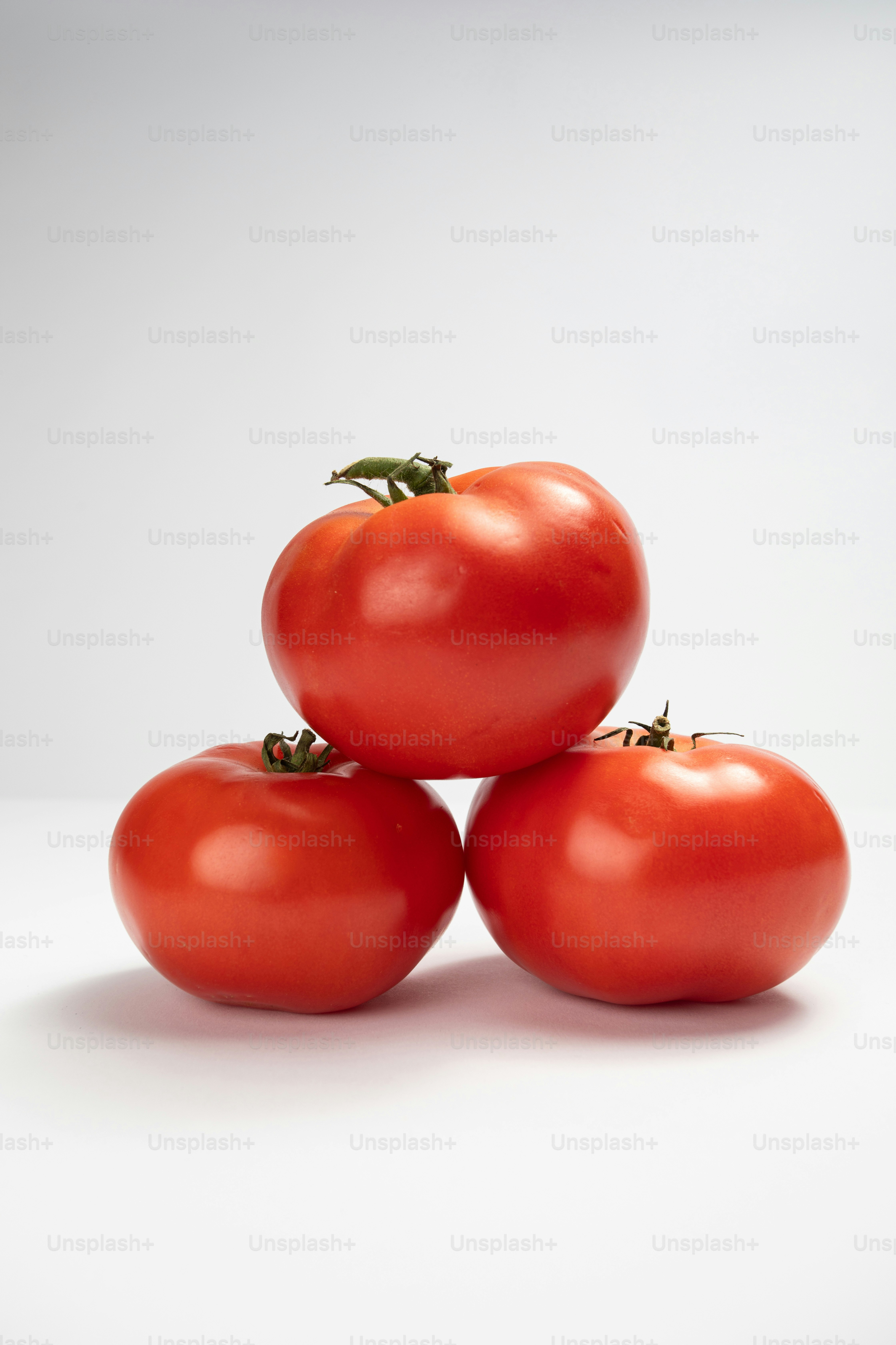 A group of four tomatoes sitting on top of each other photo – Fresh ...