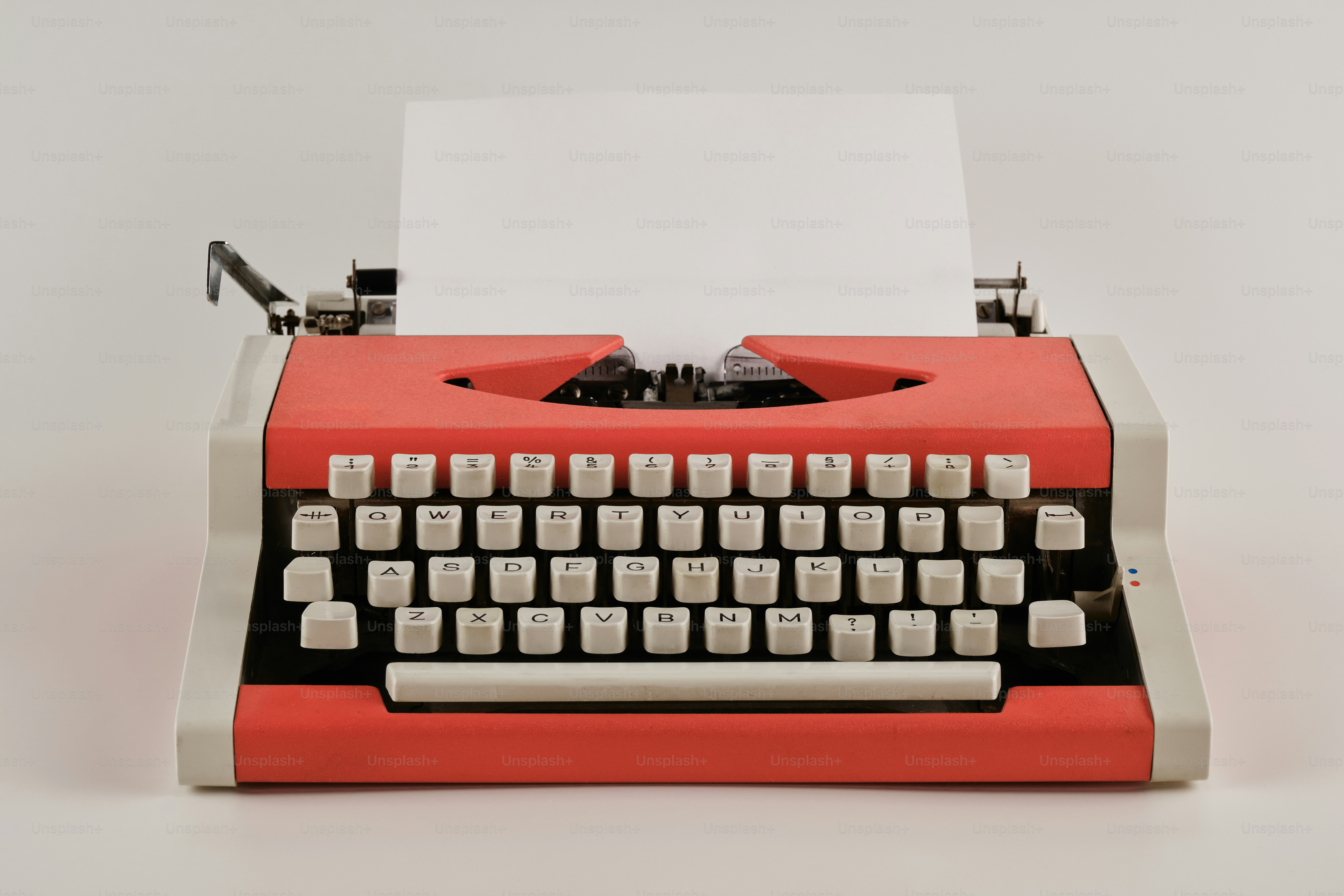 A red typewriter with a white sheet of paper on top of it photo ...