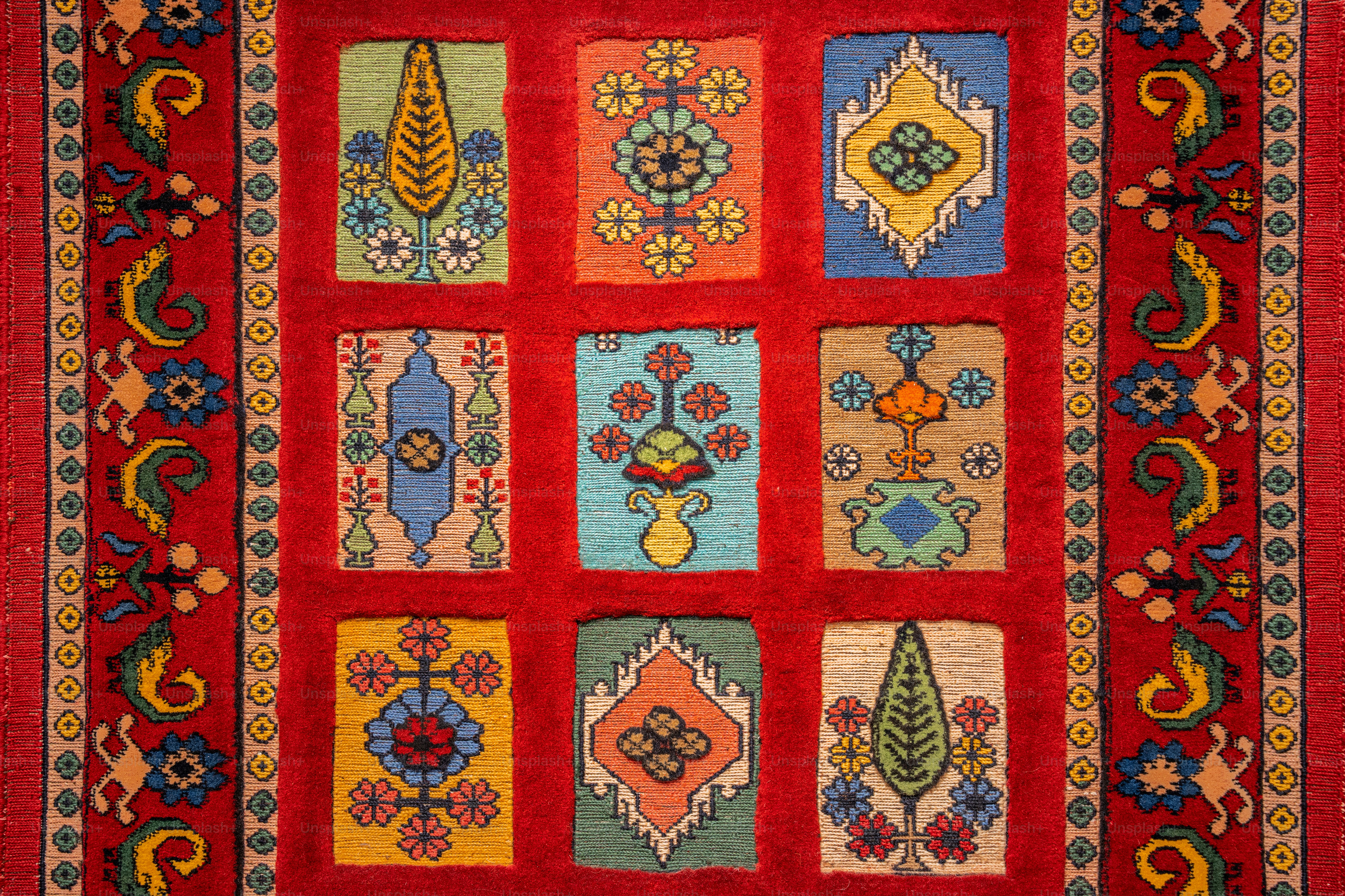 A red area rug with a bunch of different designs on it photo – Pattern ...