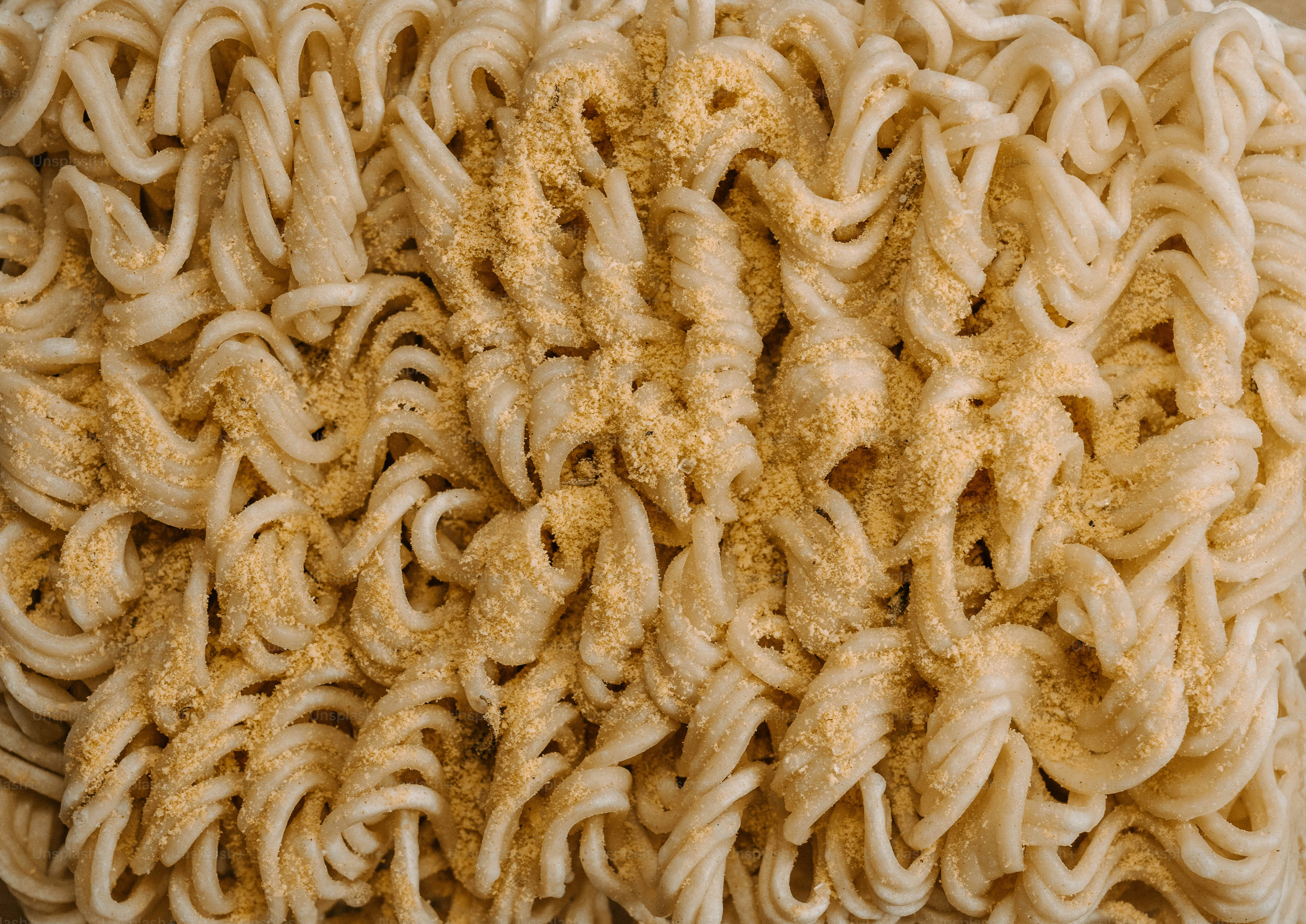 A pile of uncooked noodles sitting on top of a counter photo – Close up ...