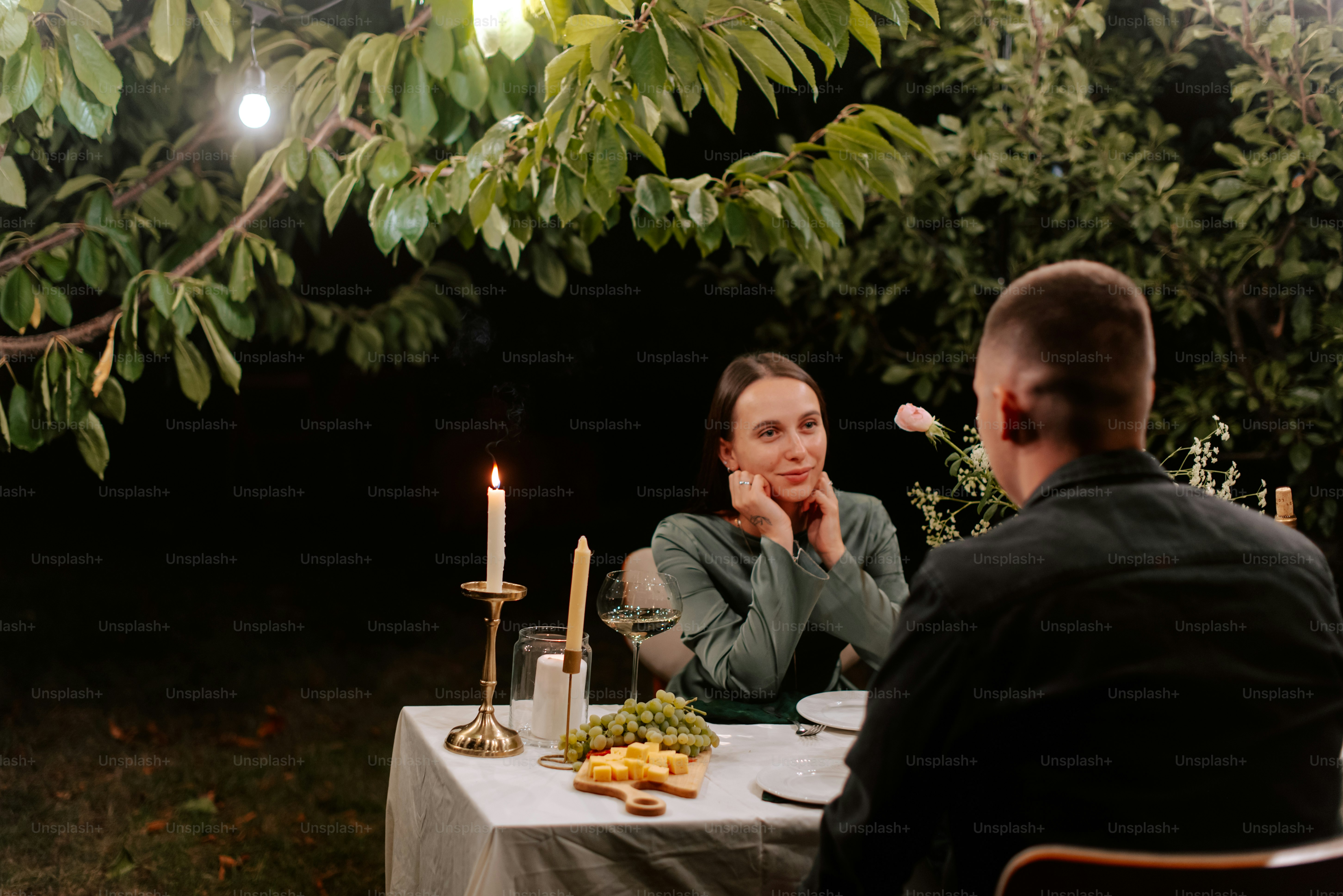 A man and a woman sitting at a dinner table photo – Date night Image on ...