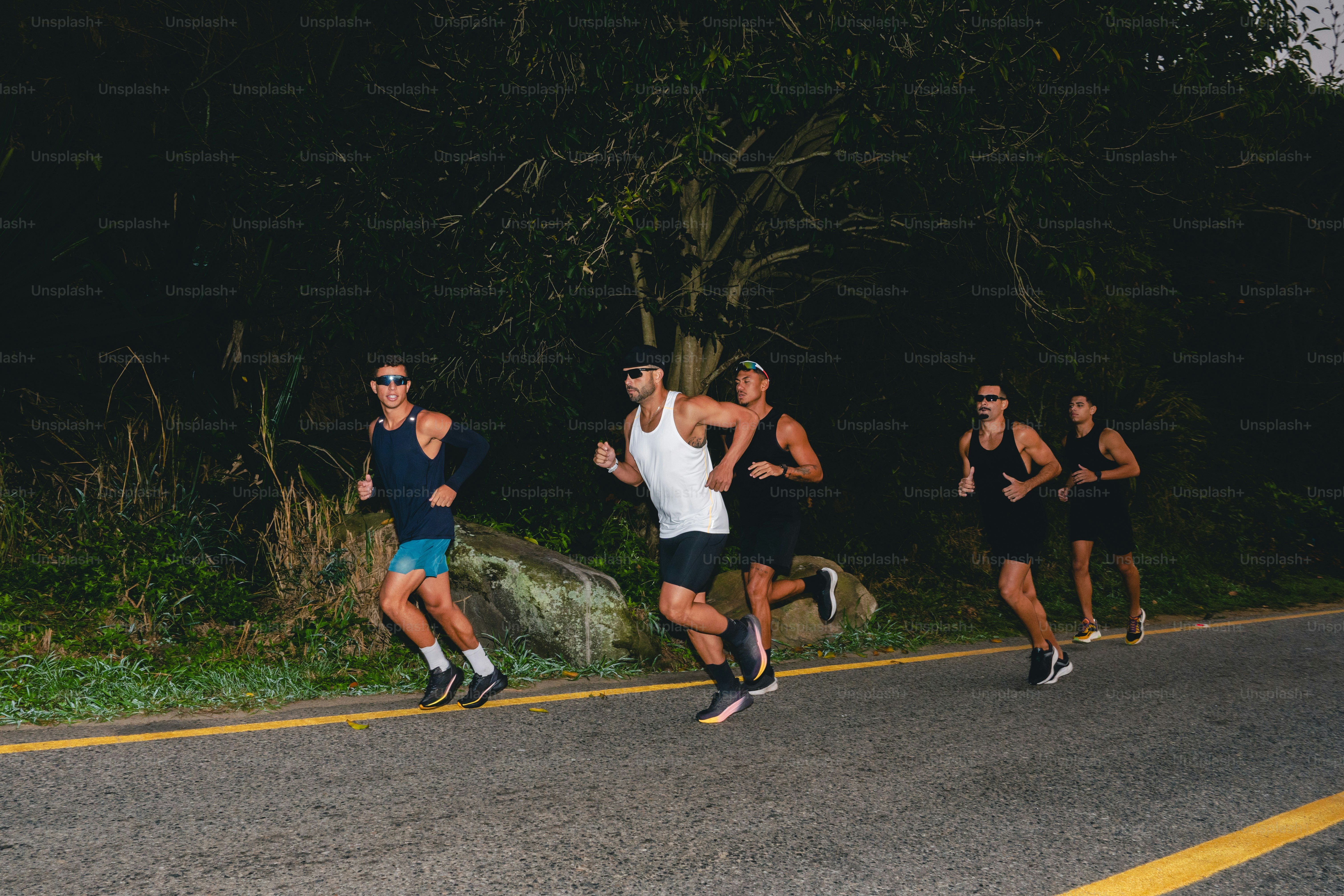 A group of people running down a road photo – Running Image on Unsplash