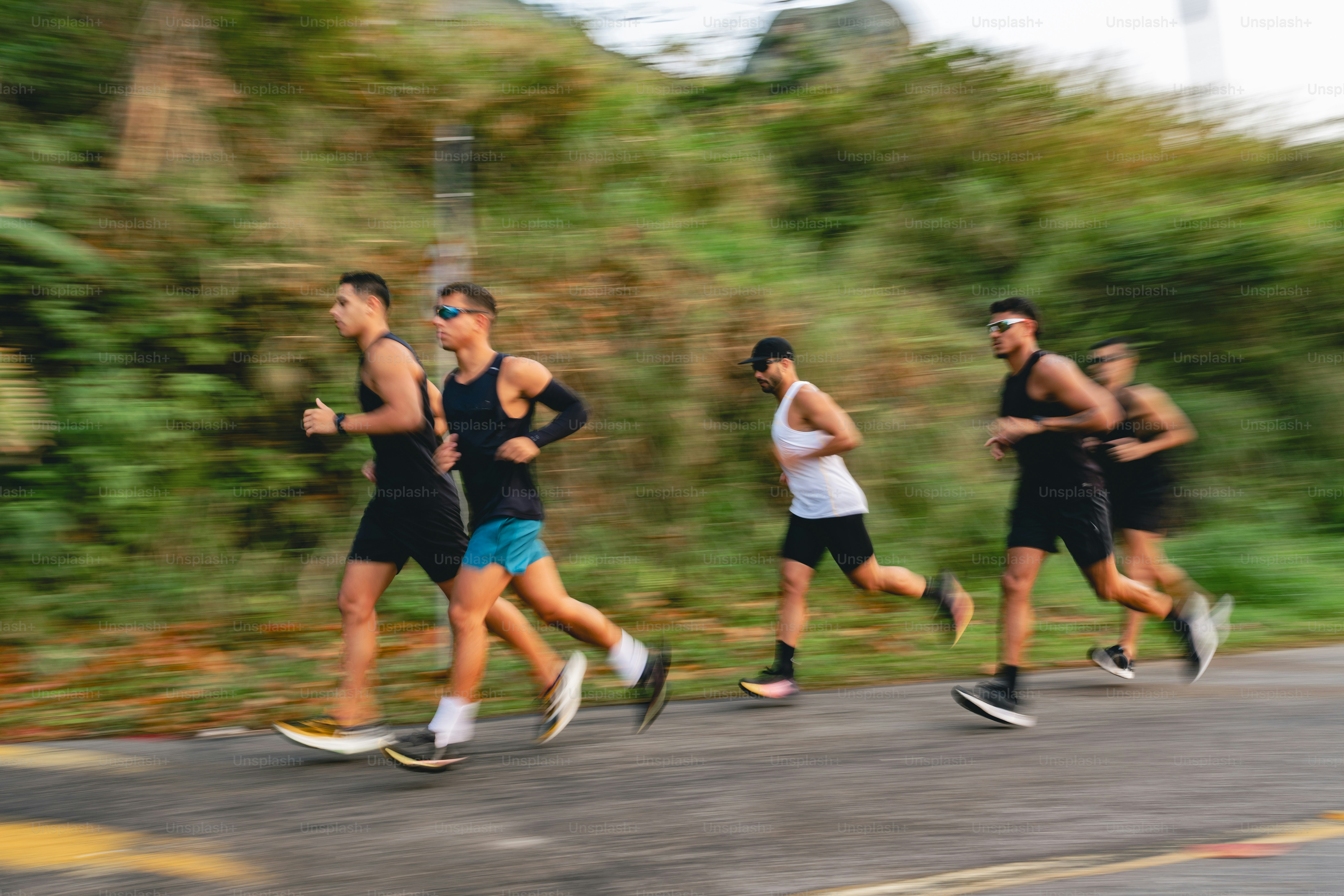 A group of men running down a street photo – Running Image on Unsplash