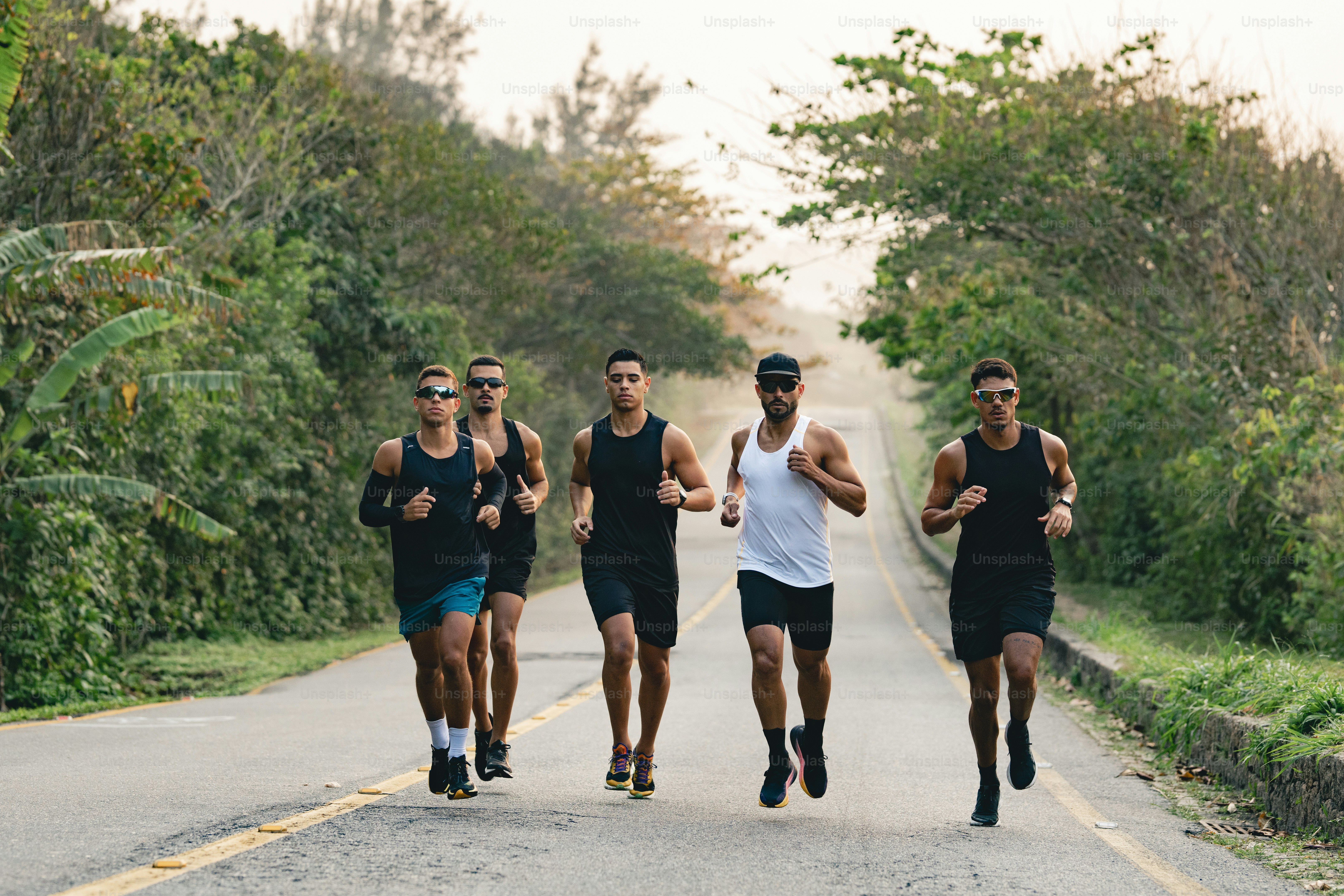 A group of people running down a road photo – Running Image on Unsplash
