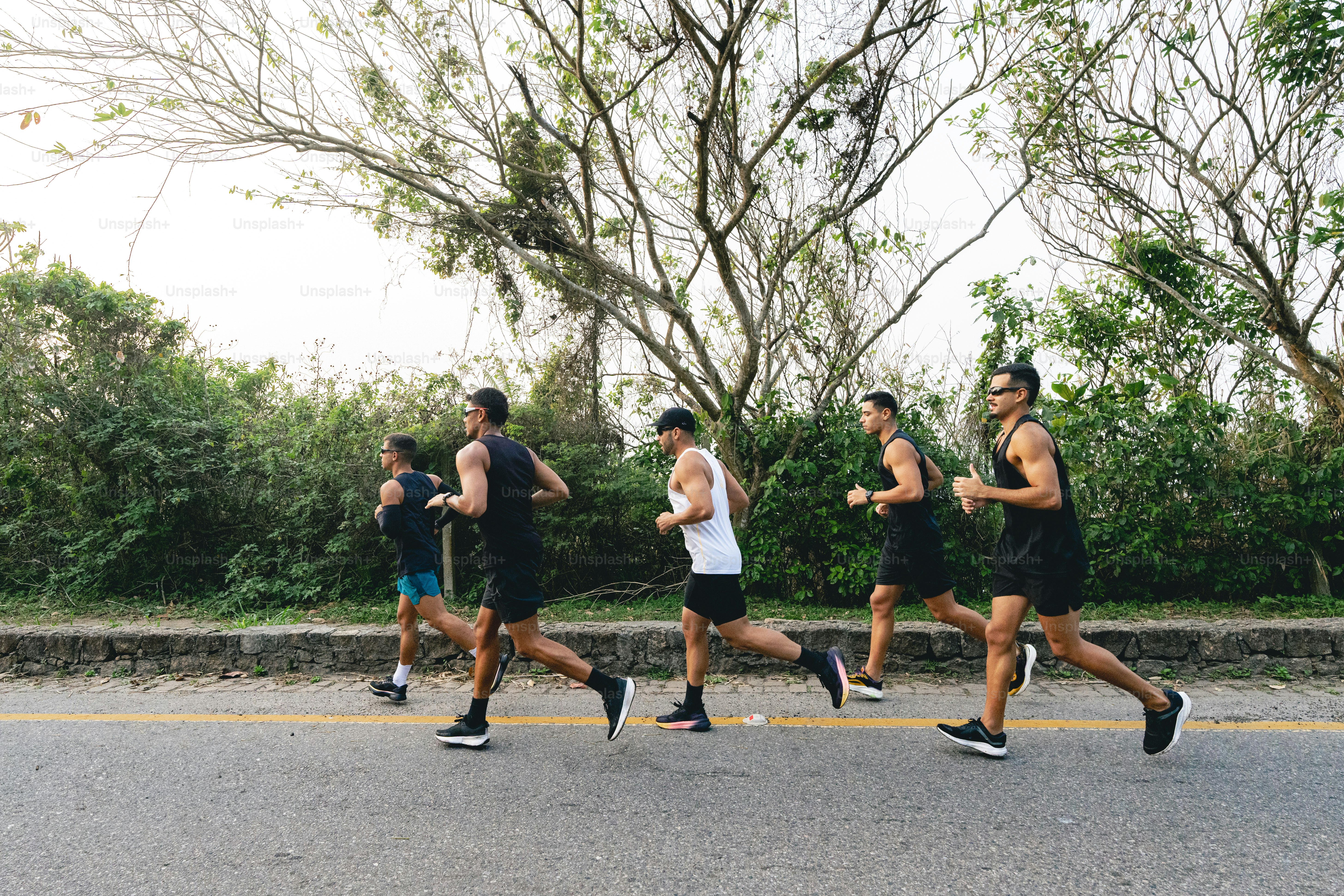 A group of people running down a street photo – Runners Image on Unsplash