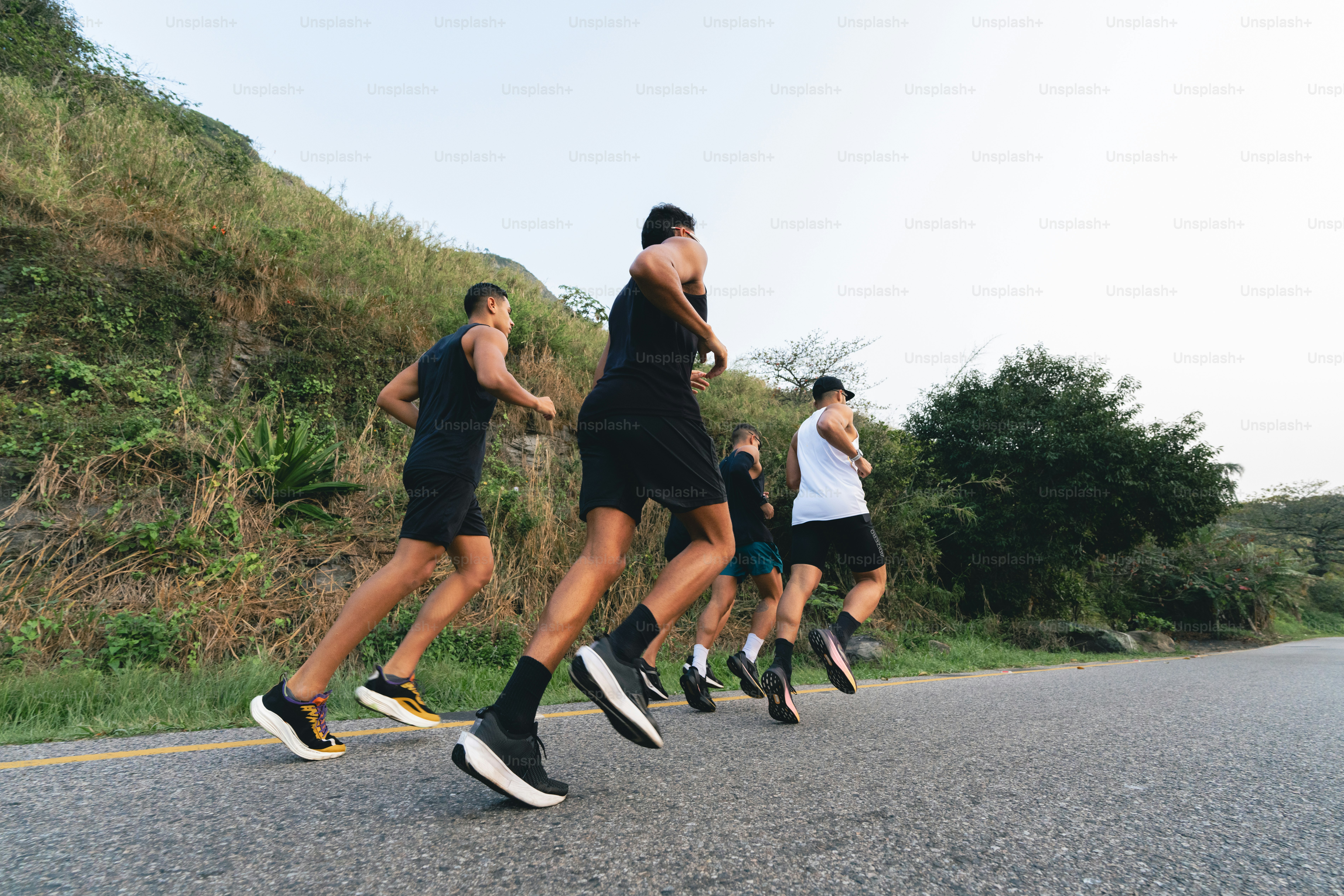 A group of people running down a road photo – Runners Image on Unsplash