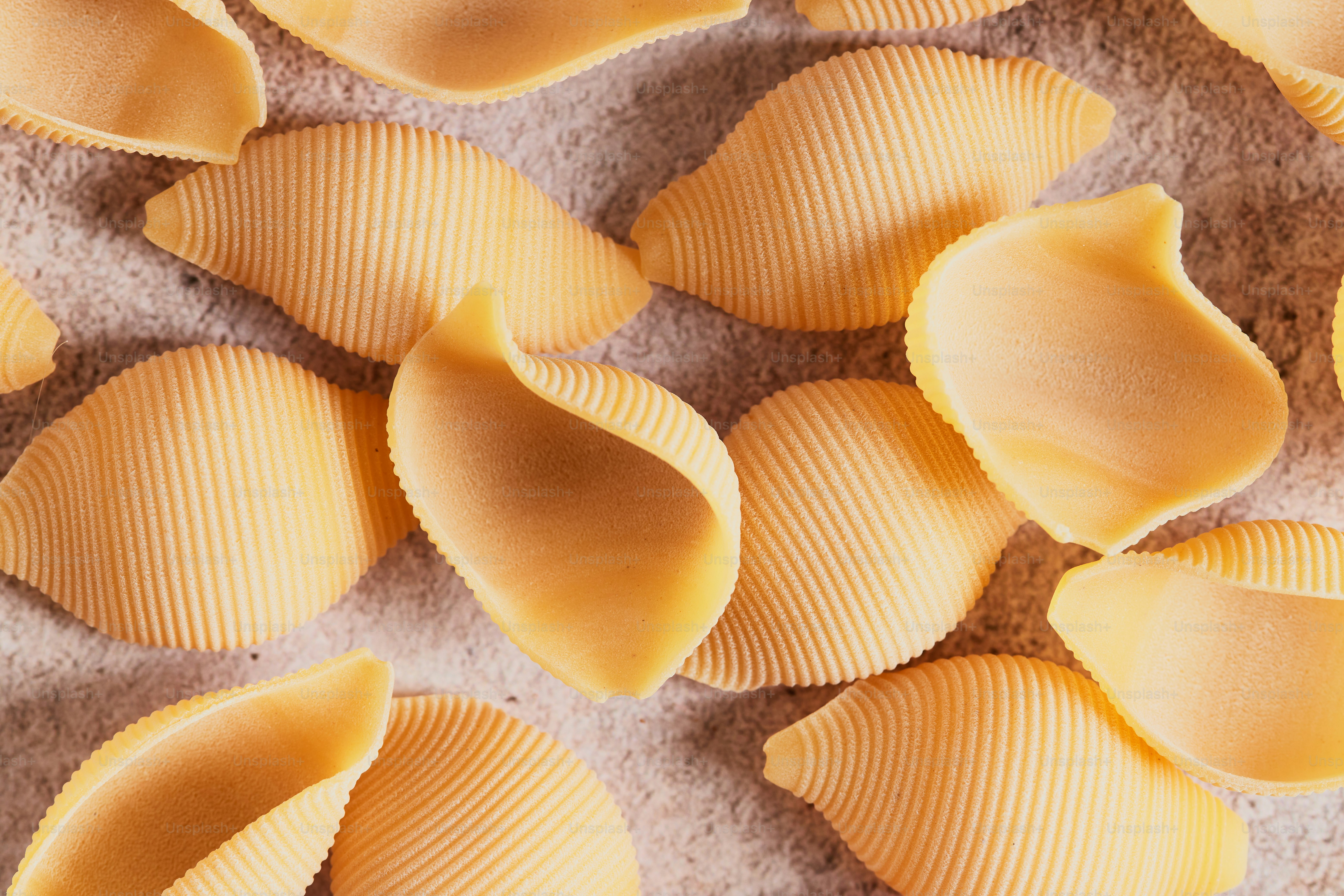 A pile of uncooked uncooked pasta shells photo – Conchiglie rigate ...