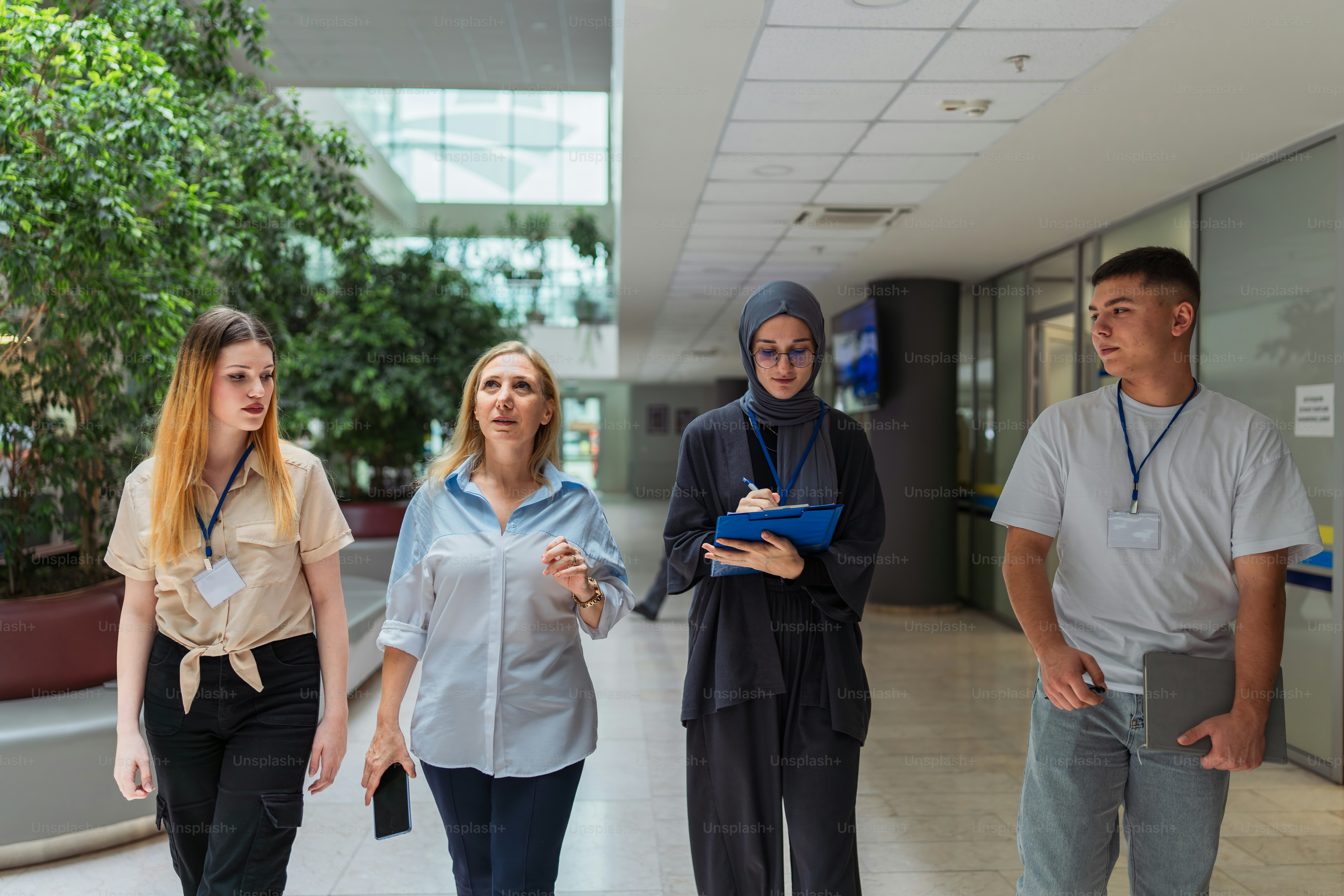A group of people walking down a hallway photo – Internship Image on ...