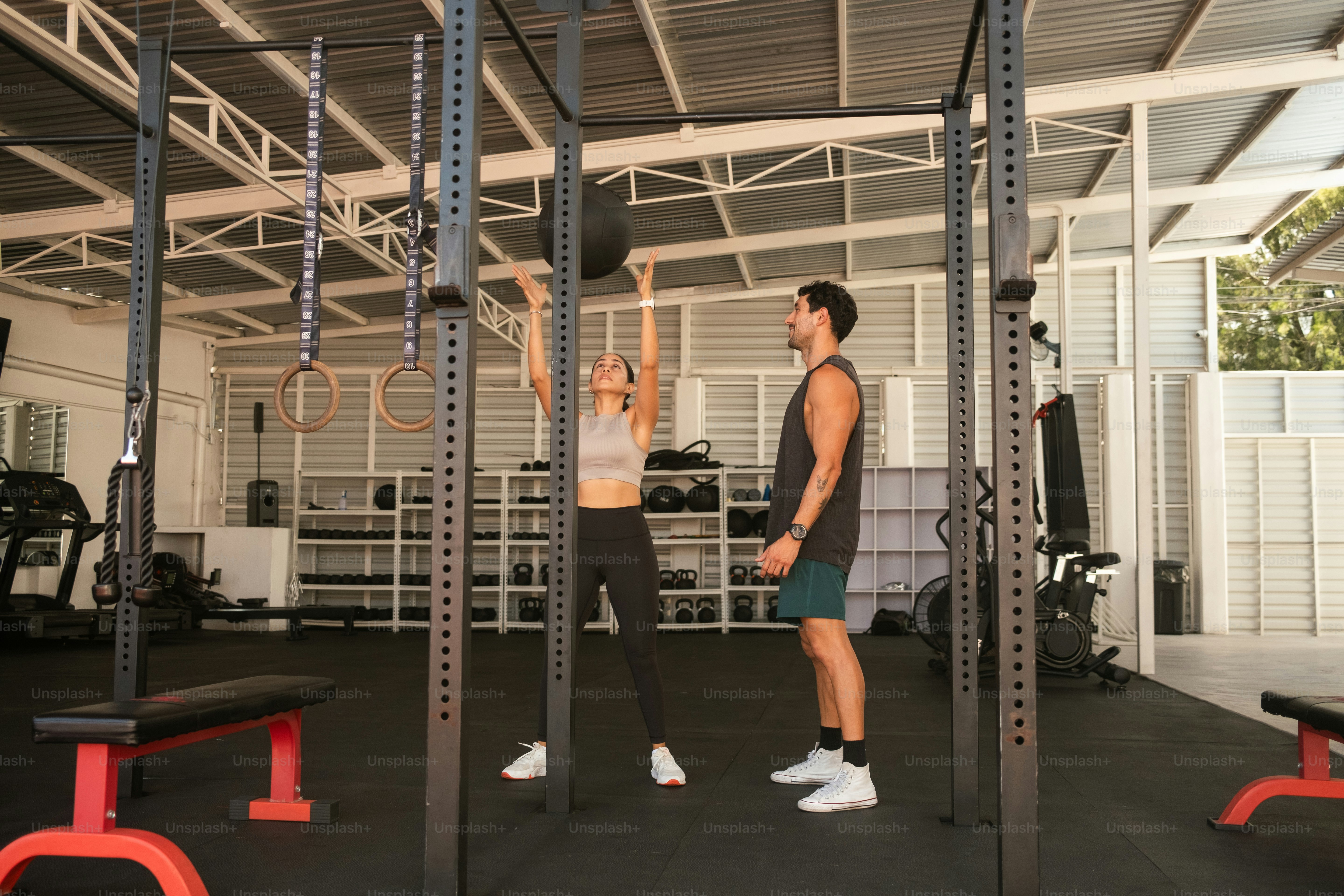 A man and a woman doing squats in a gym photo – Personal trainer Image on Unsplash
