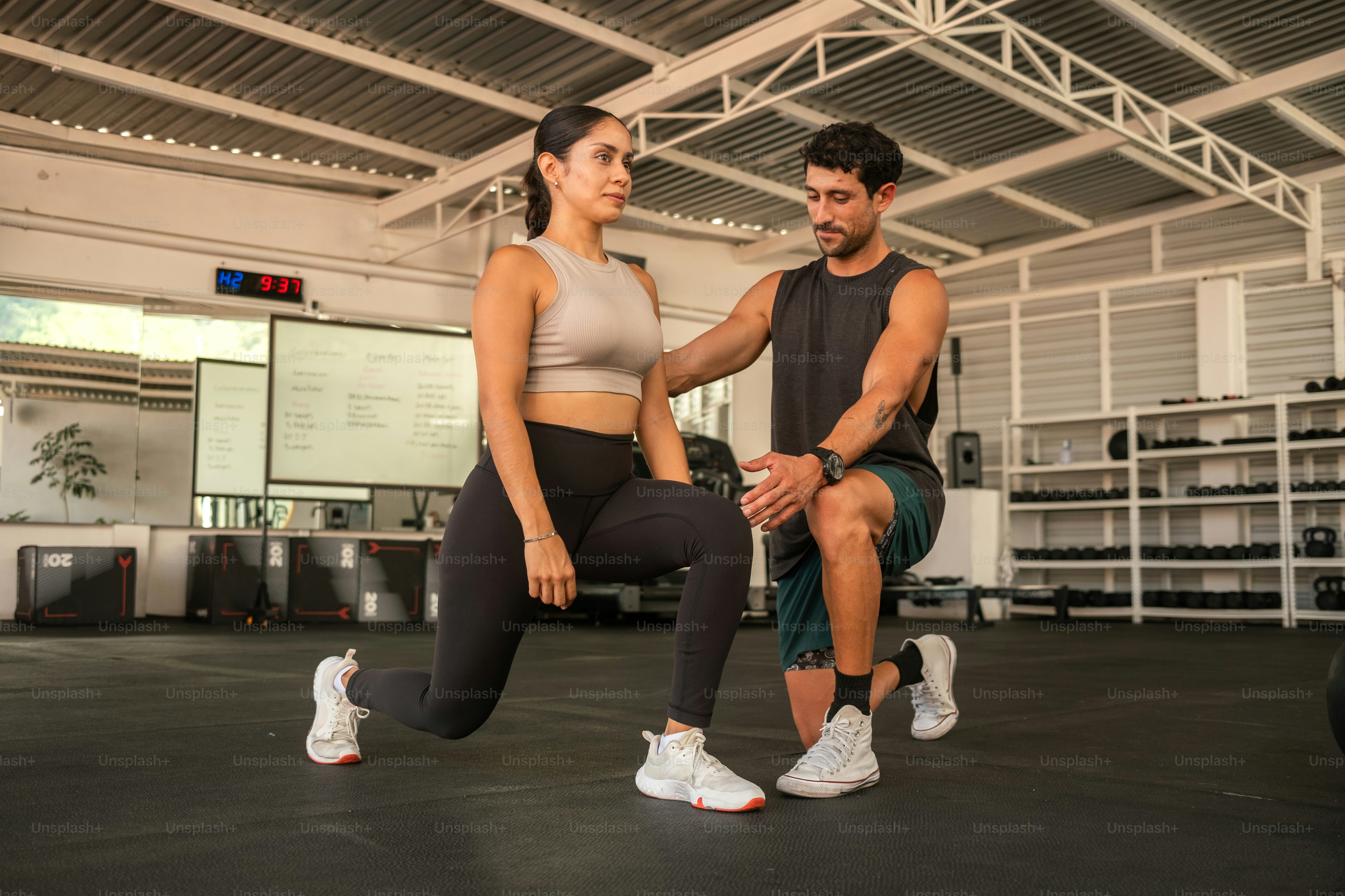 A man and a woman doing squats in a gym photo – Personal trainer Image on Unsplash