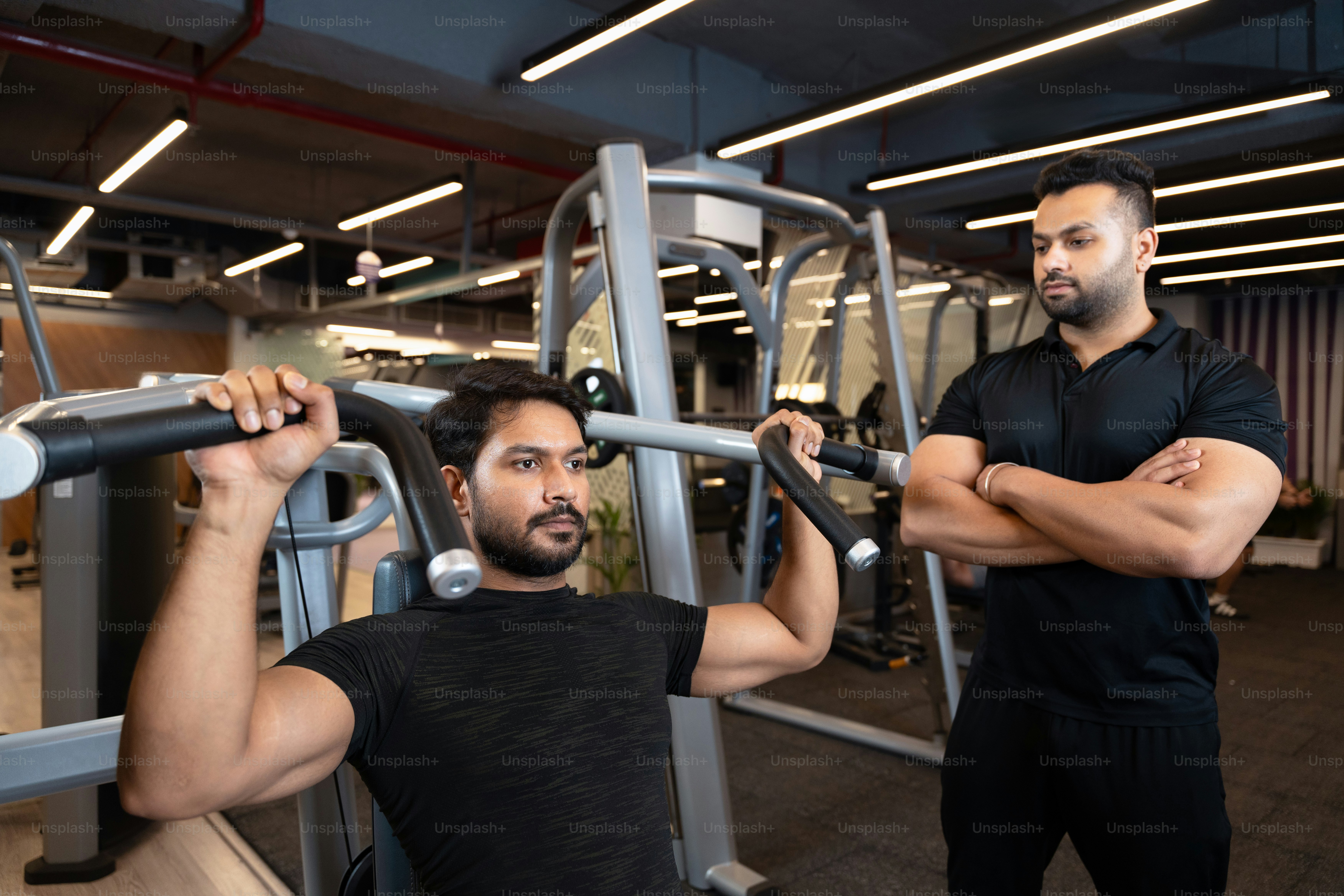 A couple of men standing next to each other in a gym photo – Gym Image ...