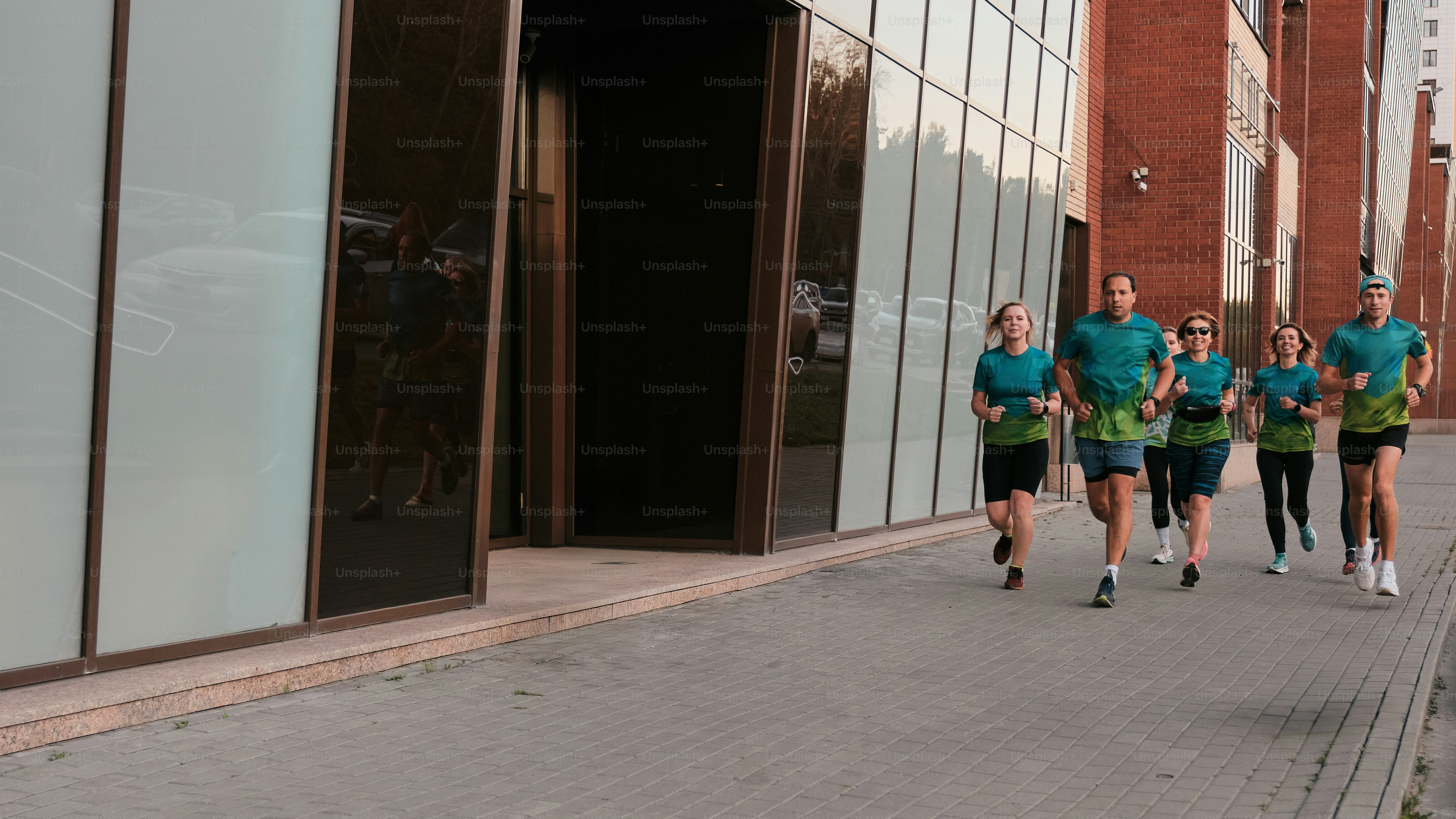 A group of people that are running down a street photo – Runners Image ...
