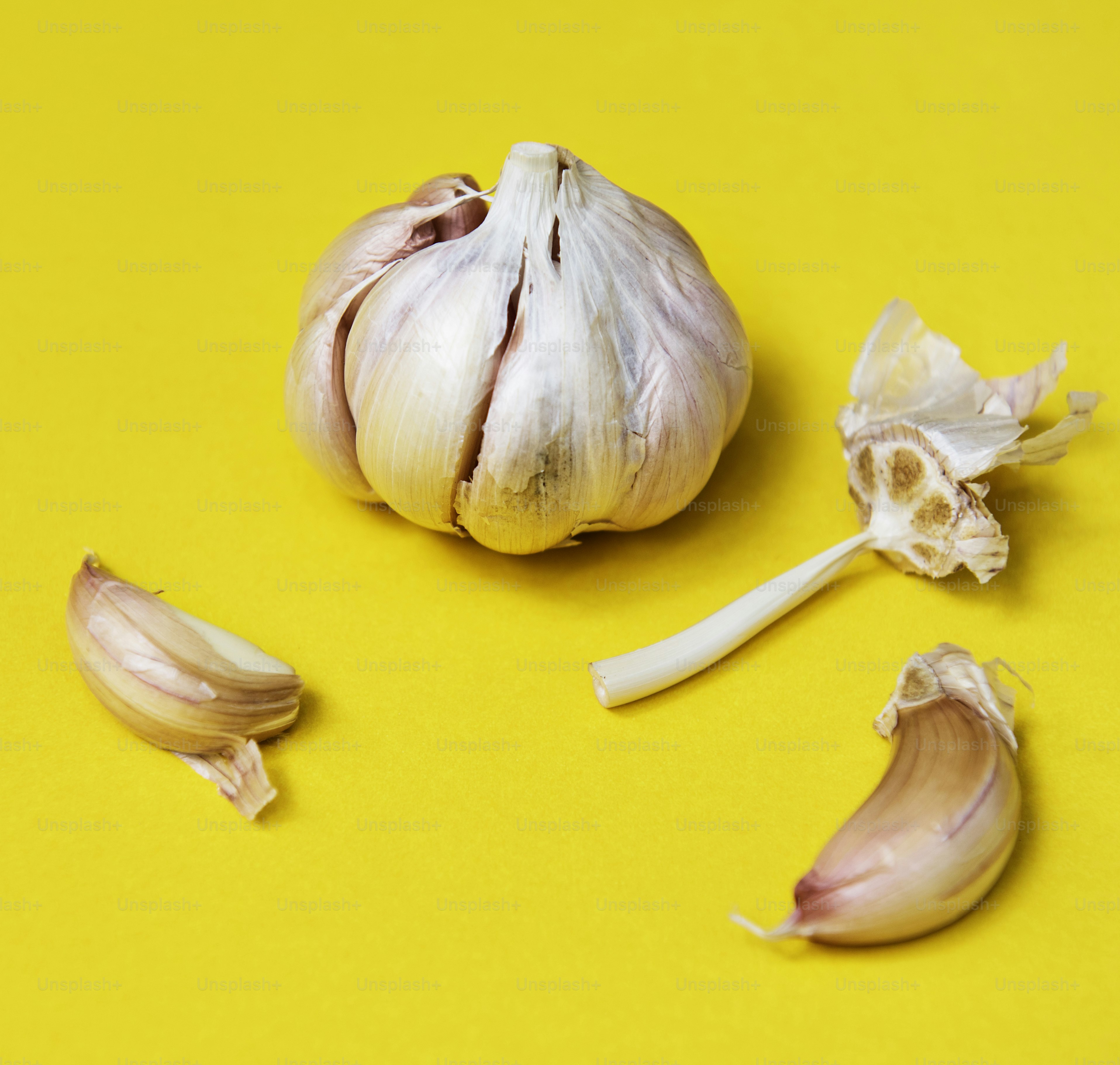 Closeup of garlic cloves on yellow background photo – Food Image on ...
