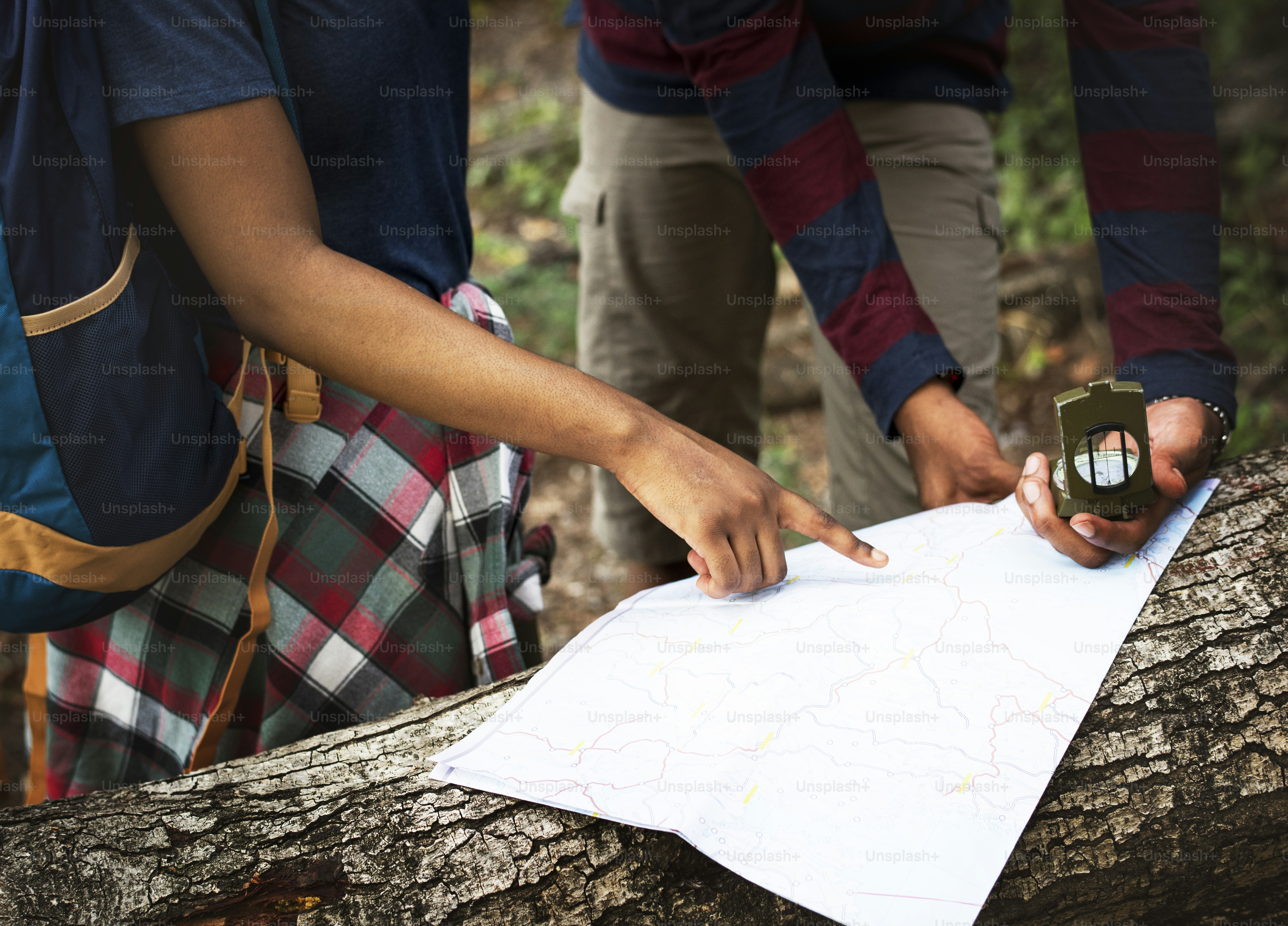 Trekking couple using map and compass in a forest photo – Forest Image ...