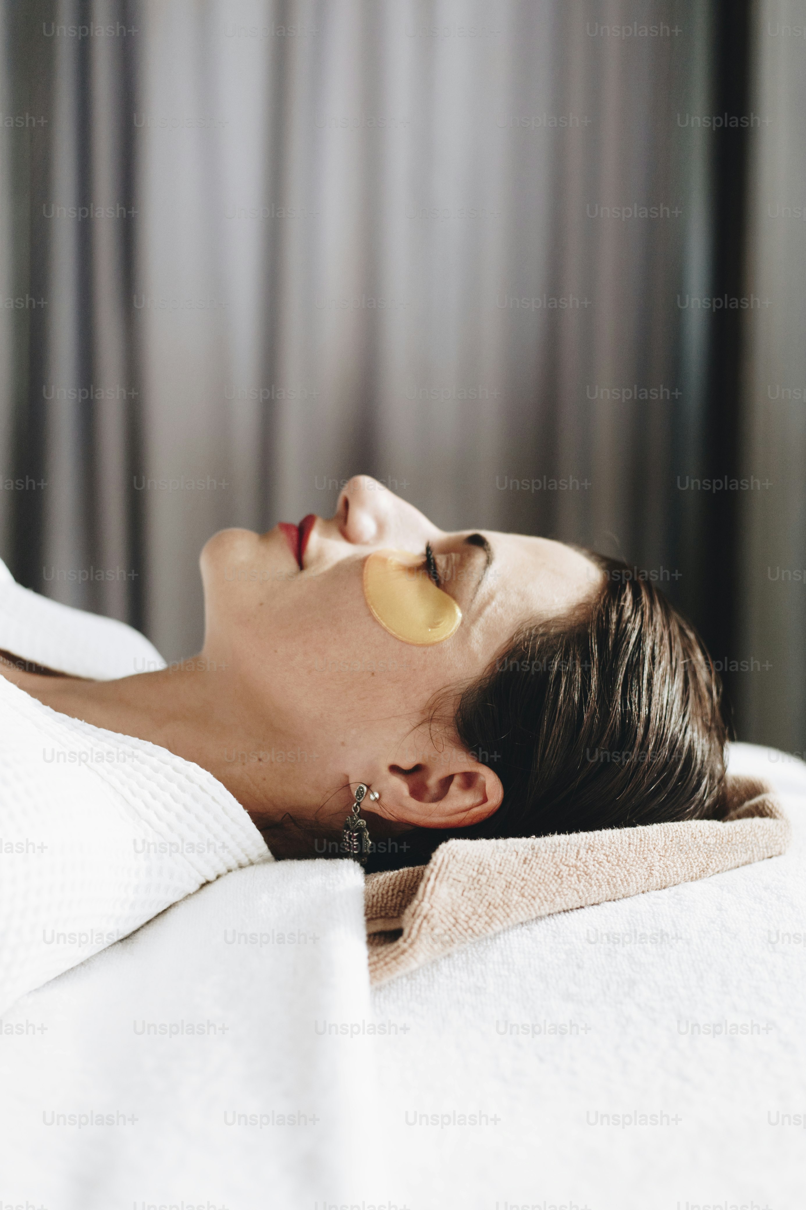 Woman relaxing with a golden eye mask treatment photo – Wellness Image ...