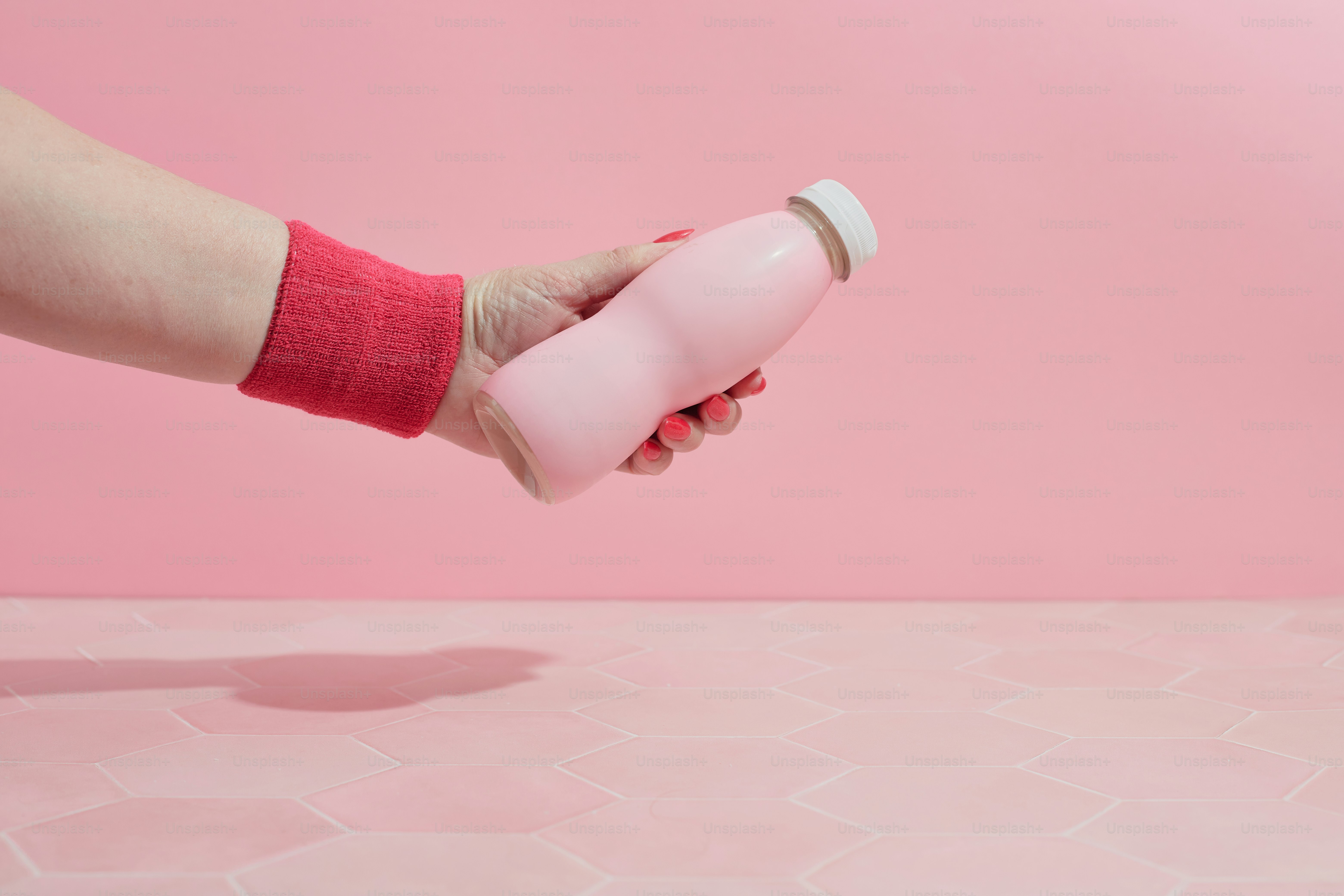 A person holding a pink object in their hand photo – Workout shake ...