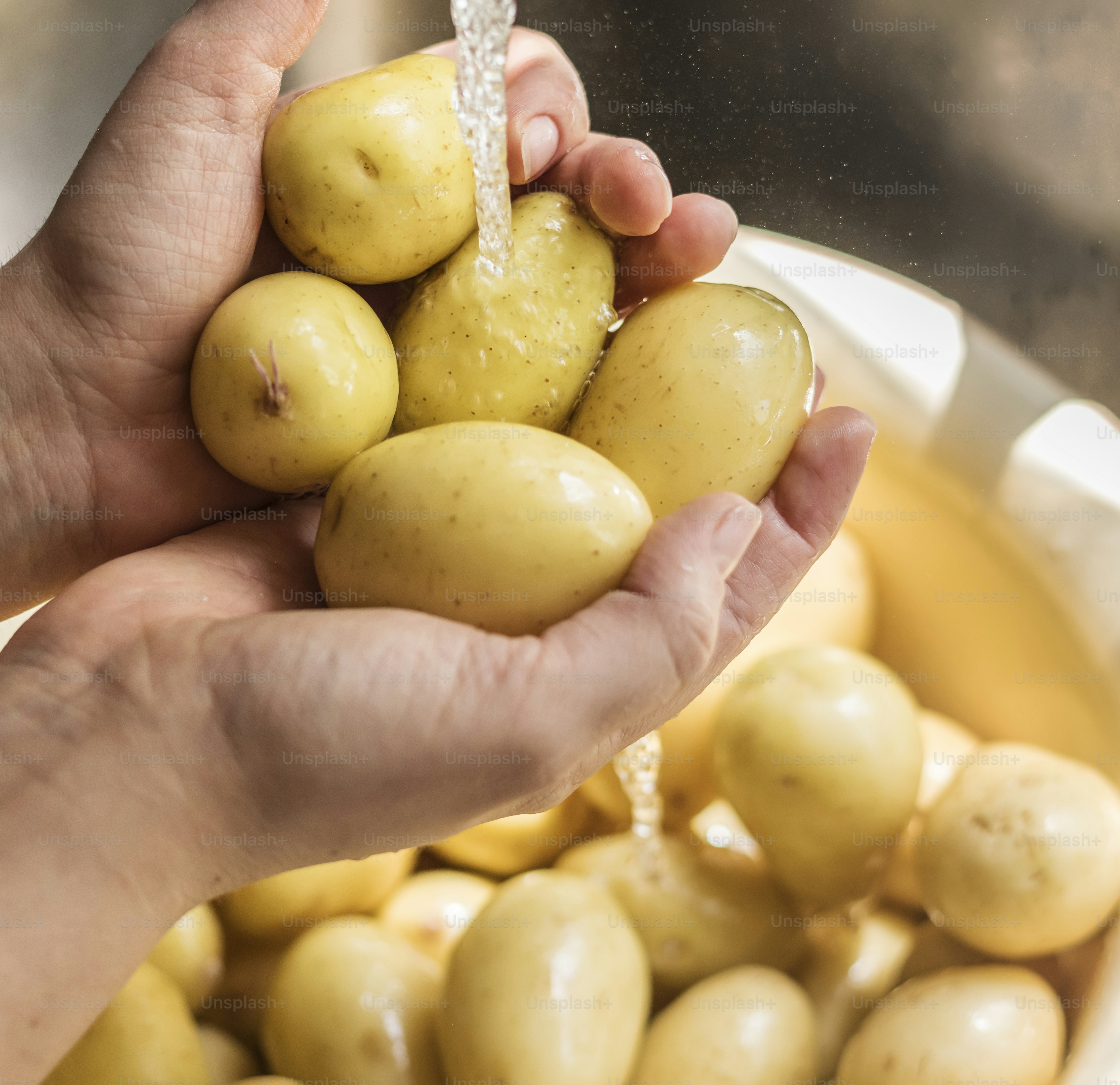 A person washing potatoes under running water food photography recipe ...