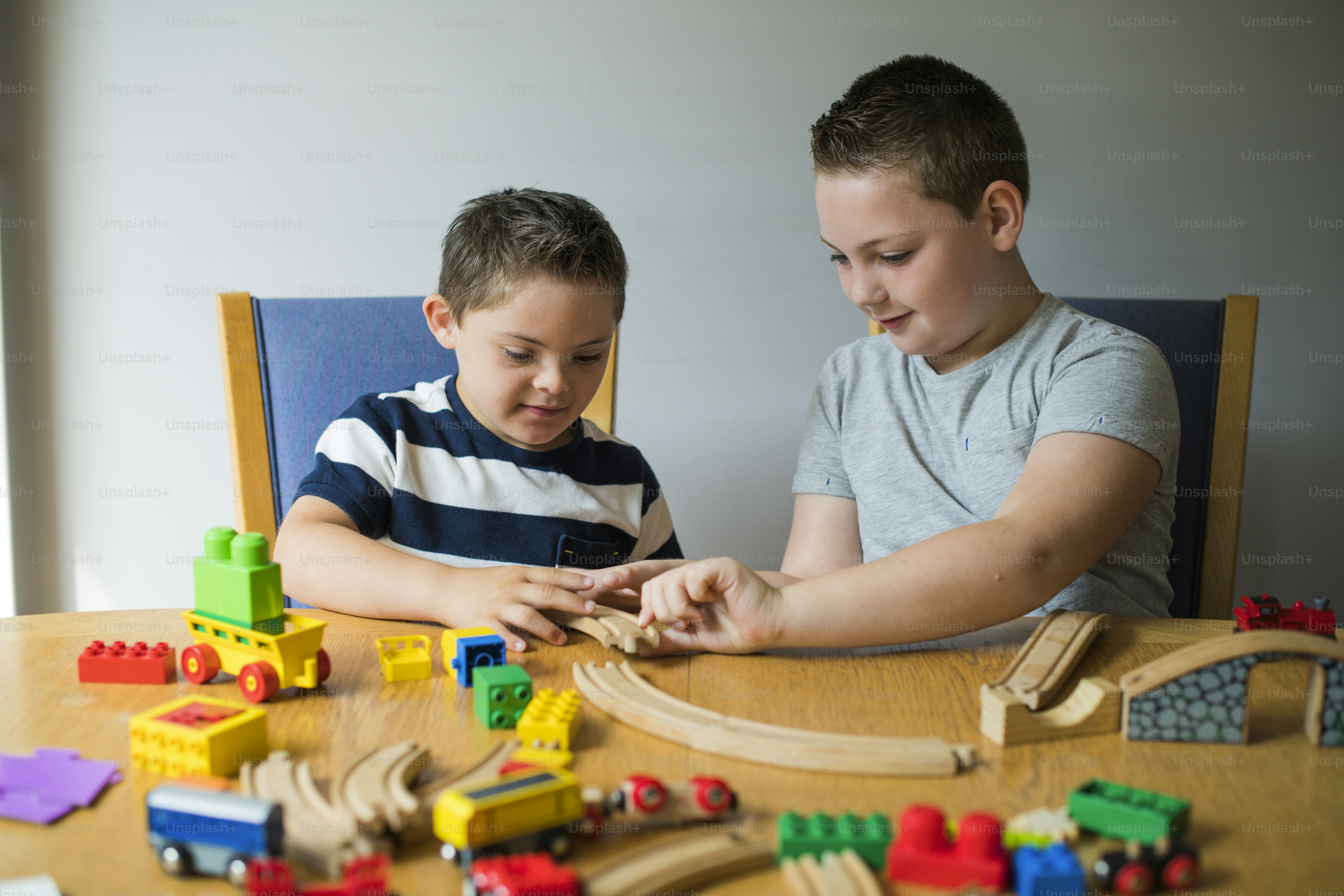 Brothers playing with blocks, trains and cars photo – Persons with ...