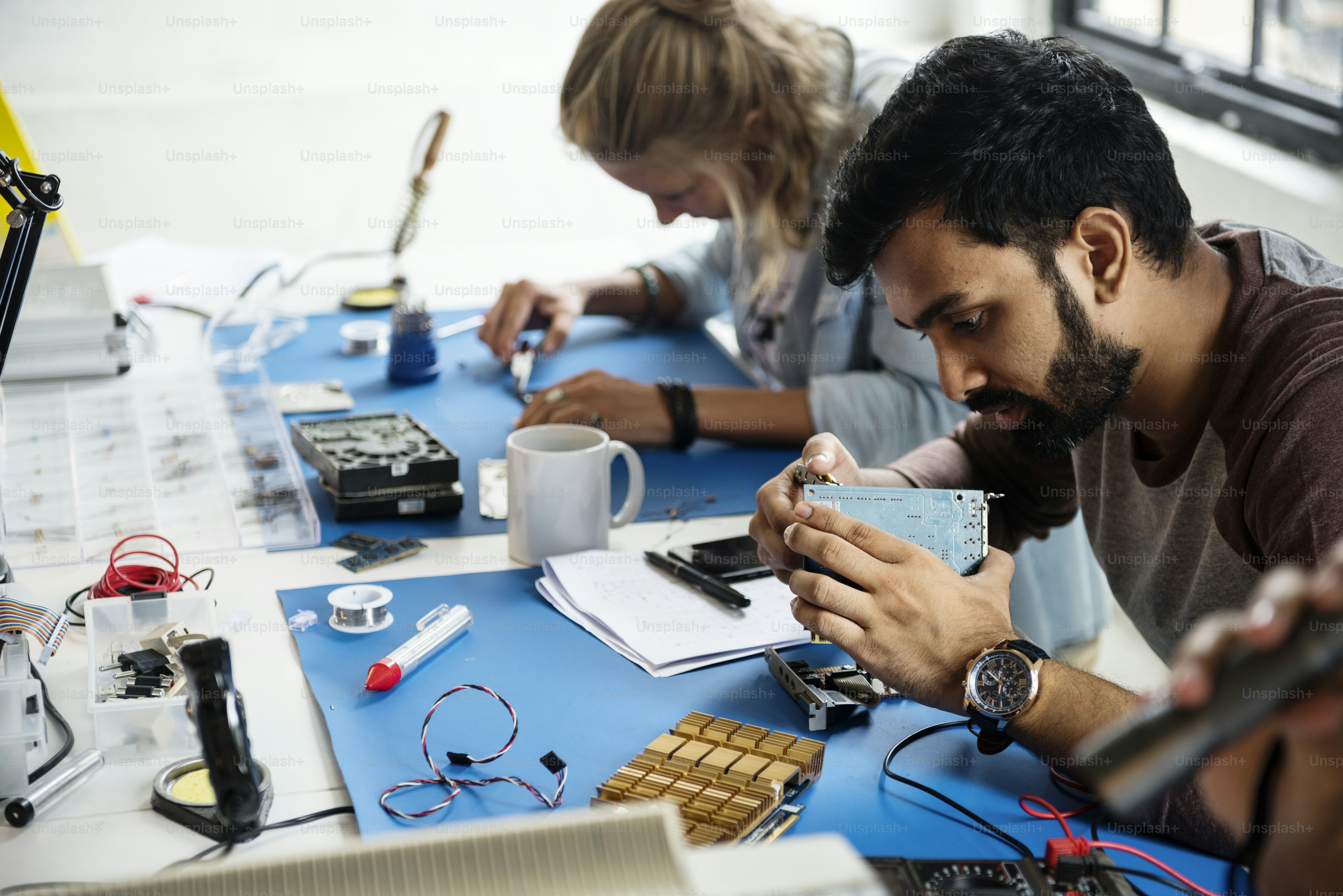 Electronics technicians team working on computer parts photo – Group of ...