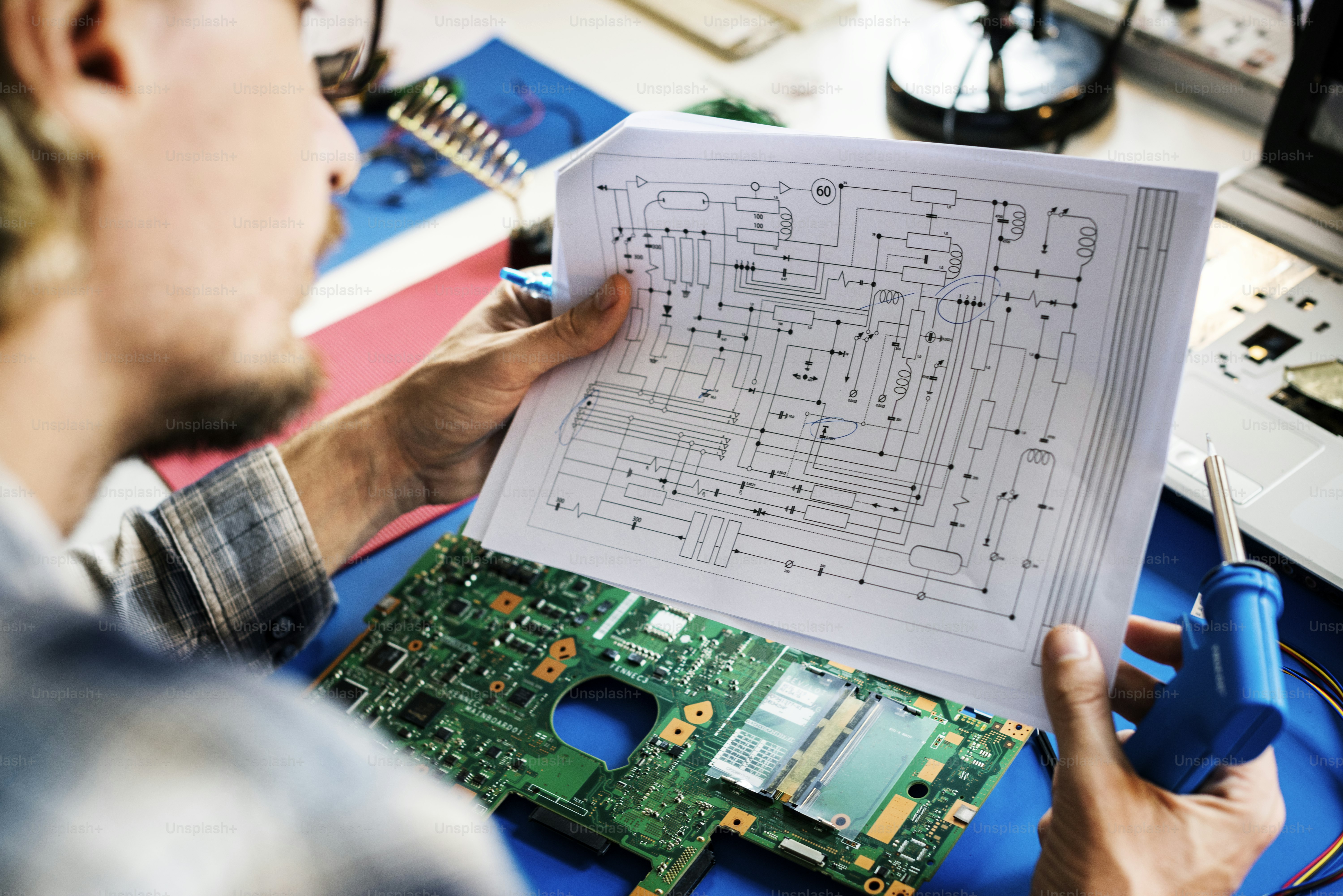 Technicians working holding electronics circuit guide paper photo ...