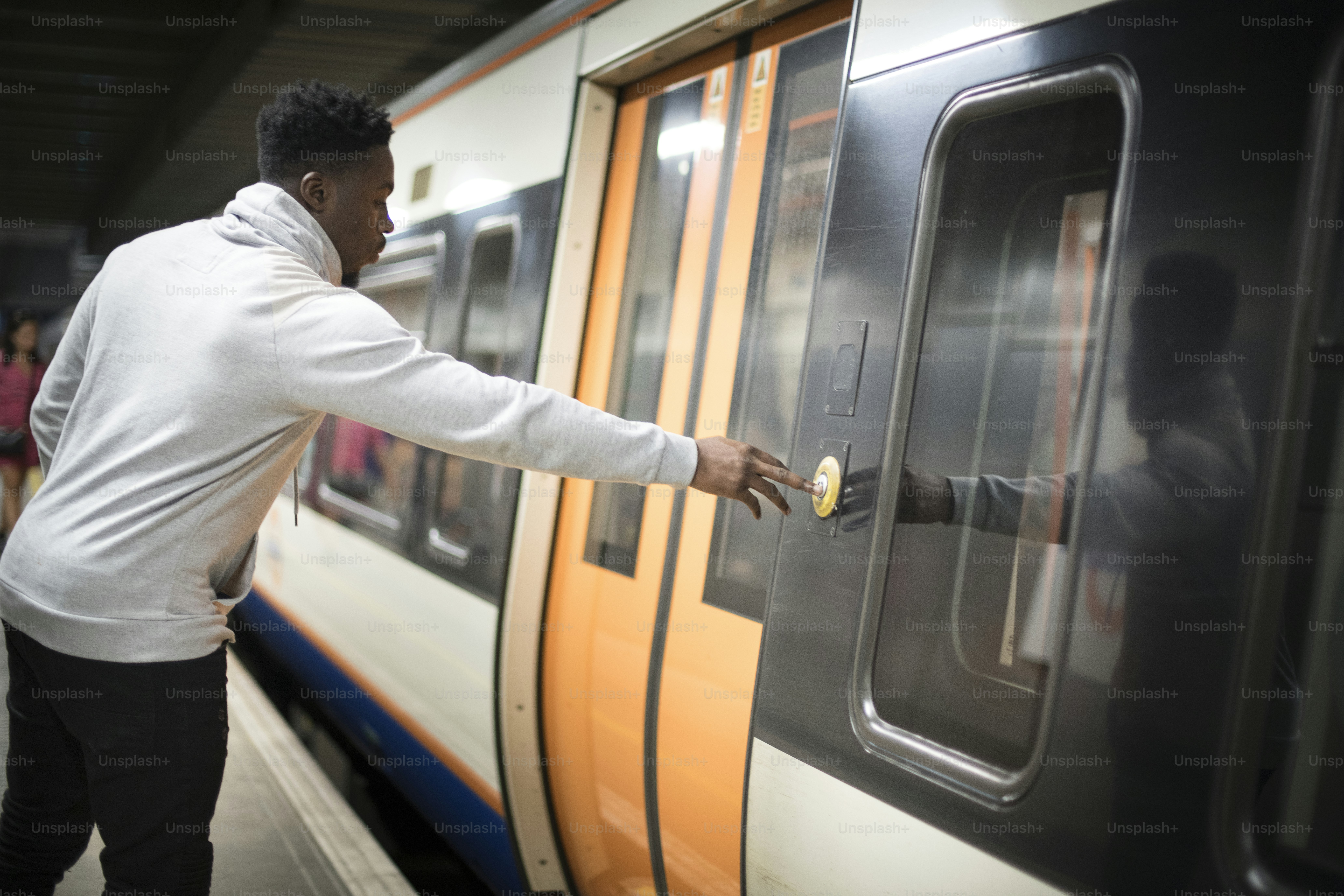 Man pushing a button to open the train doors photo – Black people Image ...