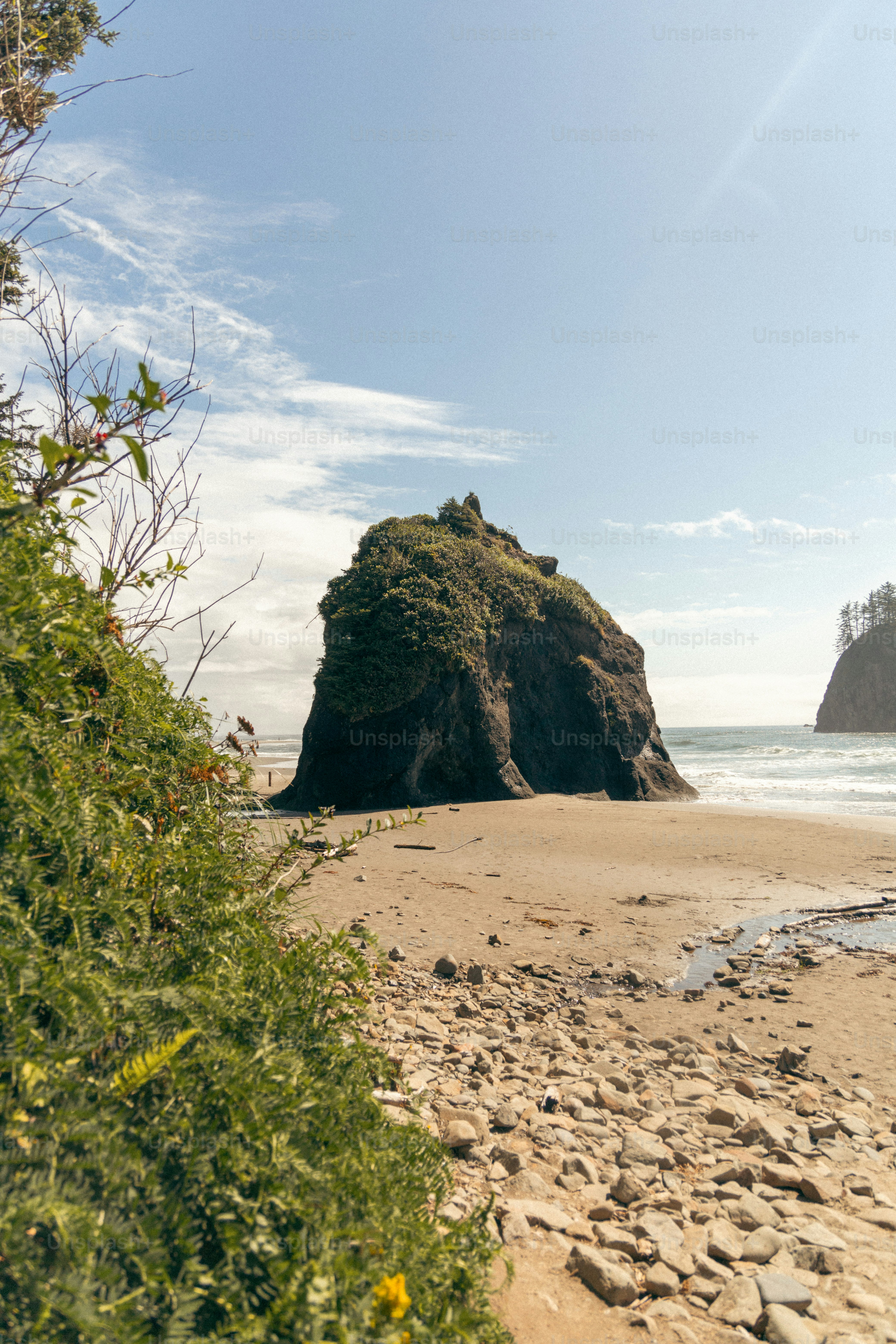 A sandy beach with a rock outcropping in the distance photo – Outdoors ...