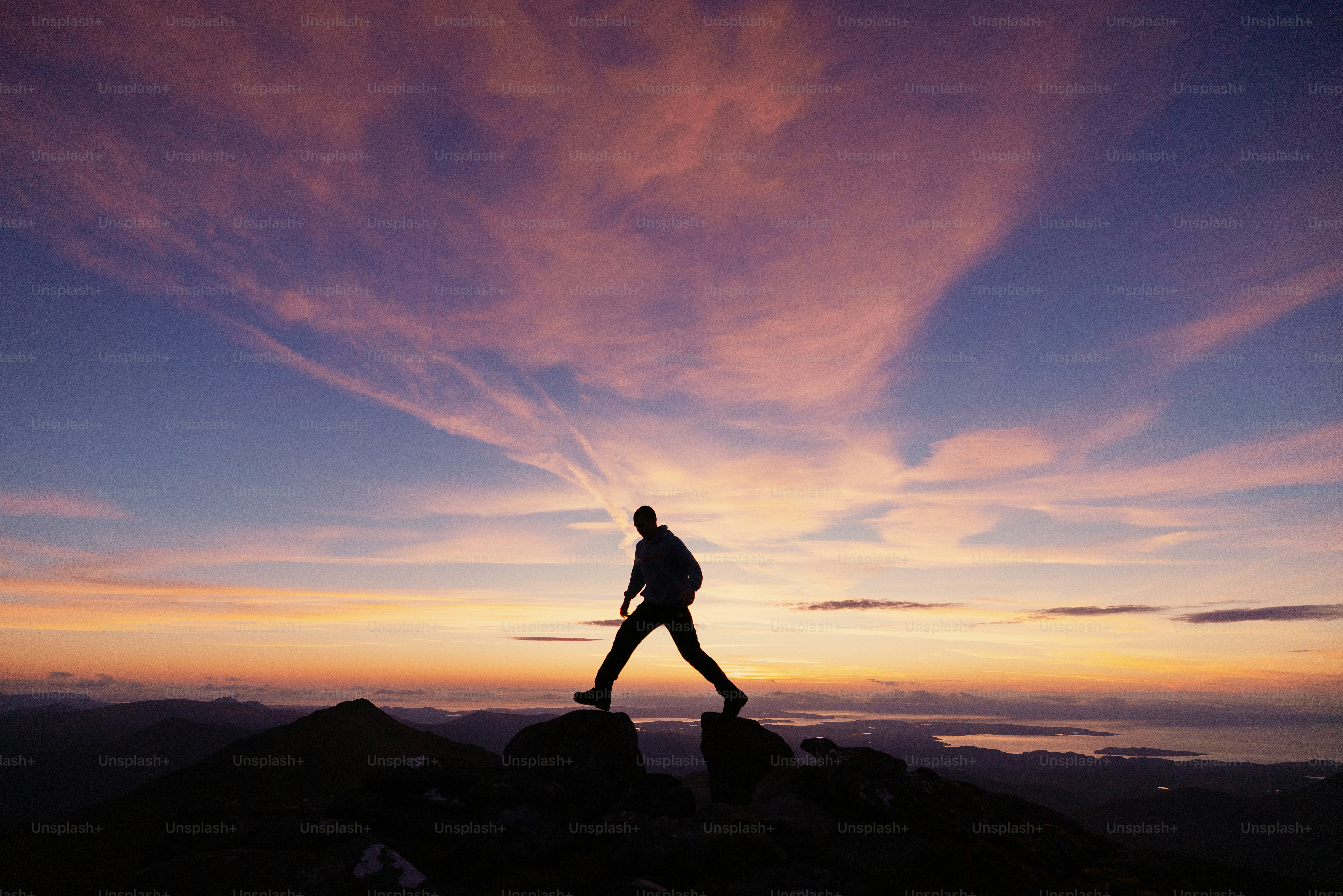 A man standing on top of a mountain at sunset photo – Travel Image on ...