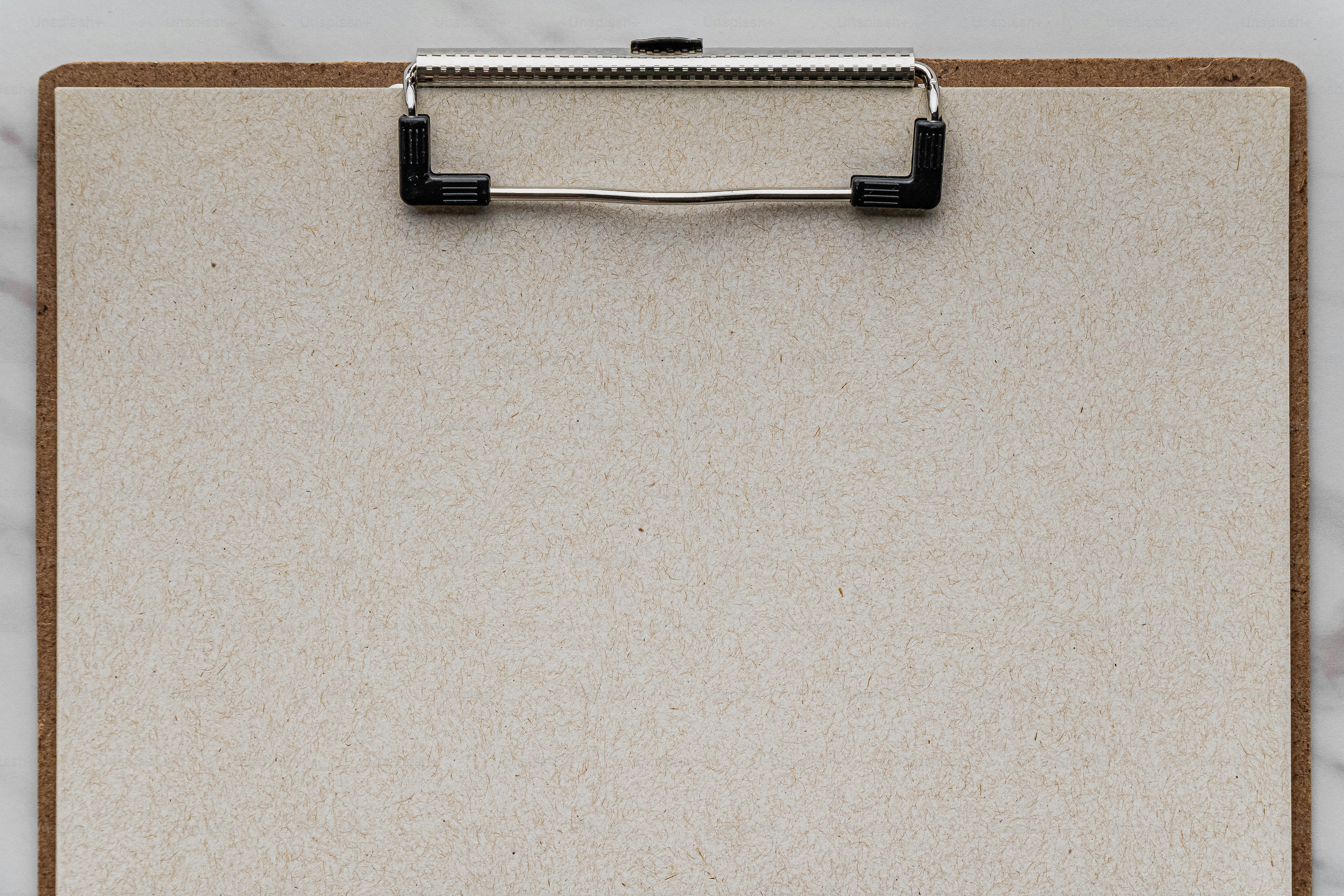A clipboard with a handle on a marble surface photo – Paper texture ...