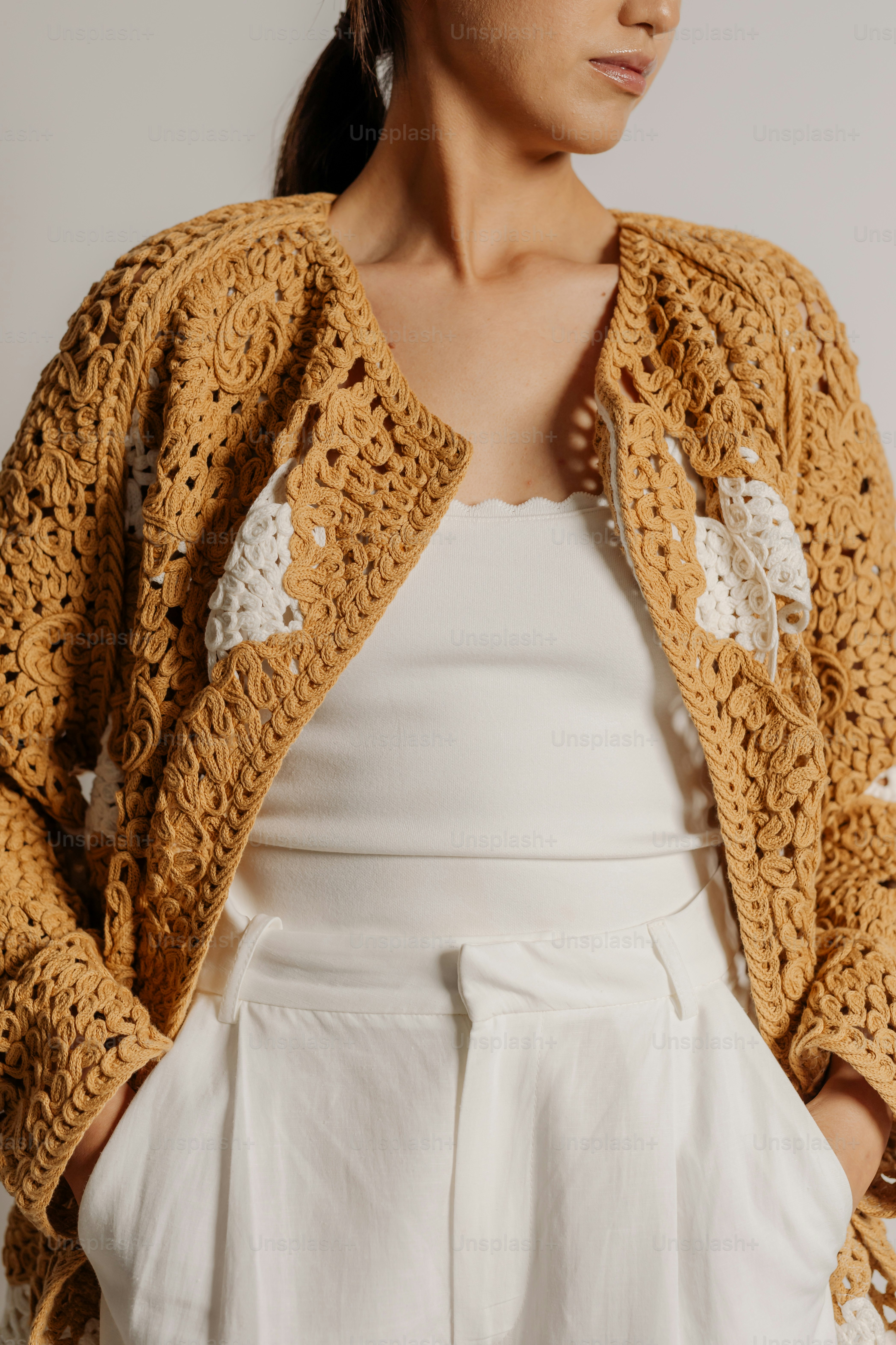 A woman wearing a yellow crochet jacket and white pants photo – Fashion ...