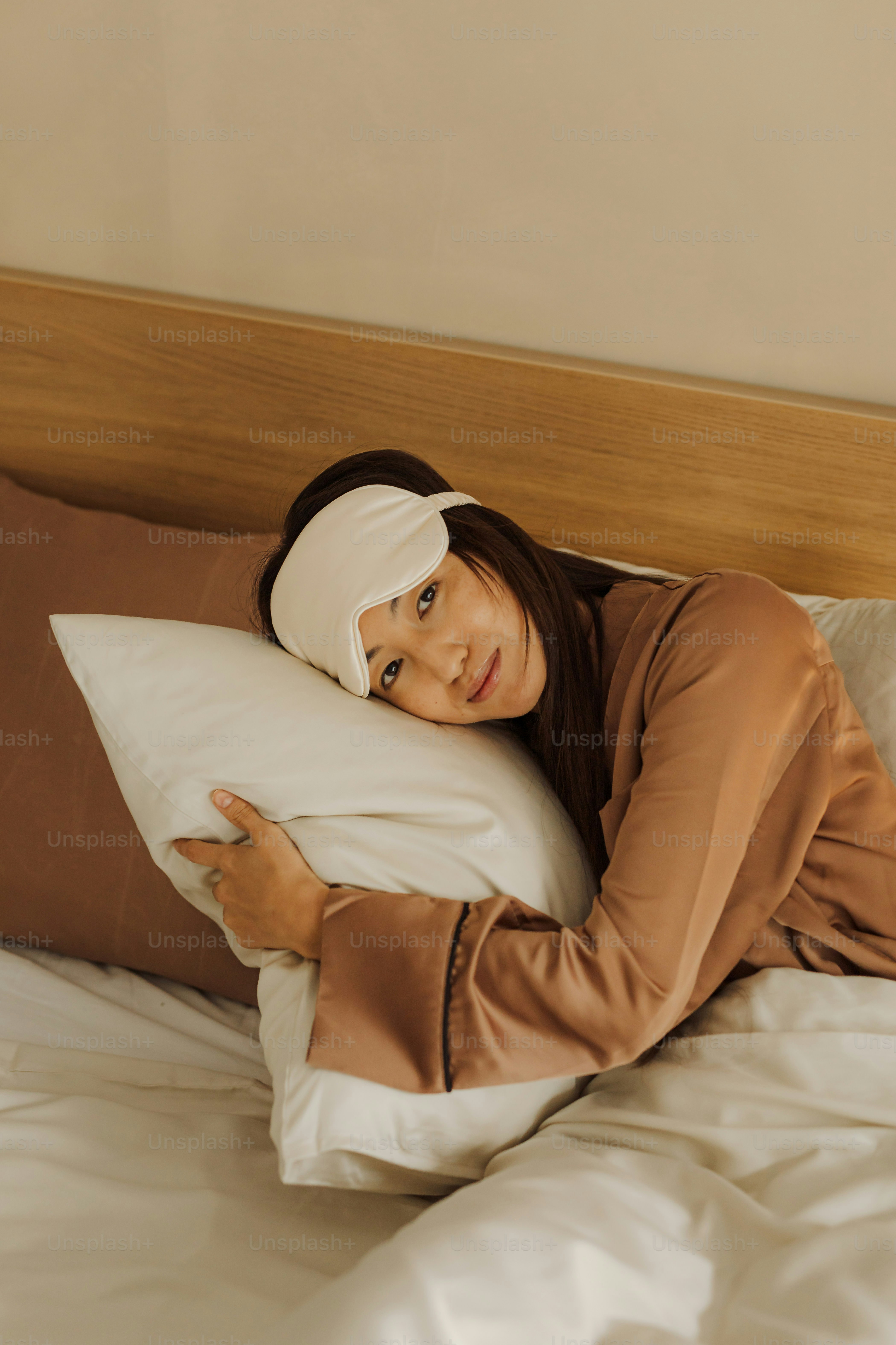 Une femme allongée sur un lit tenant un oreiller photo – Image de Soins ...