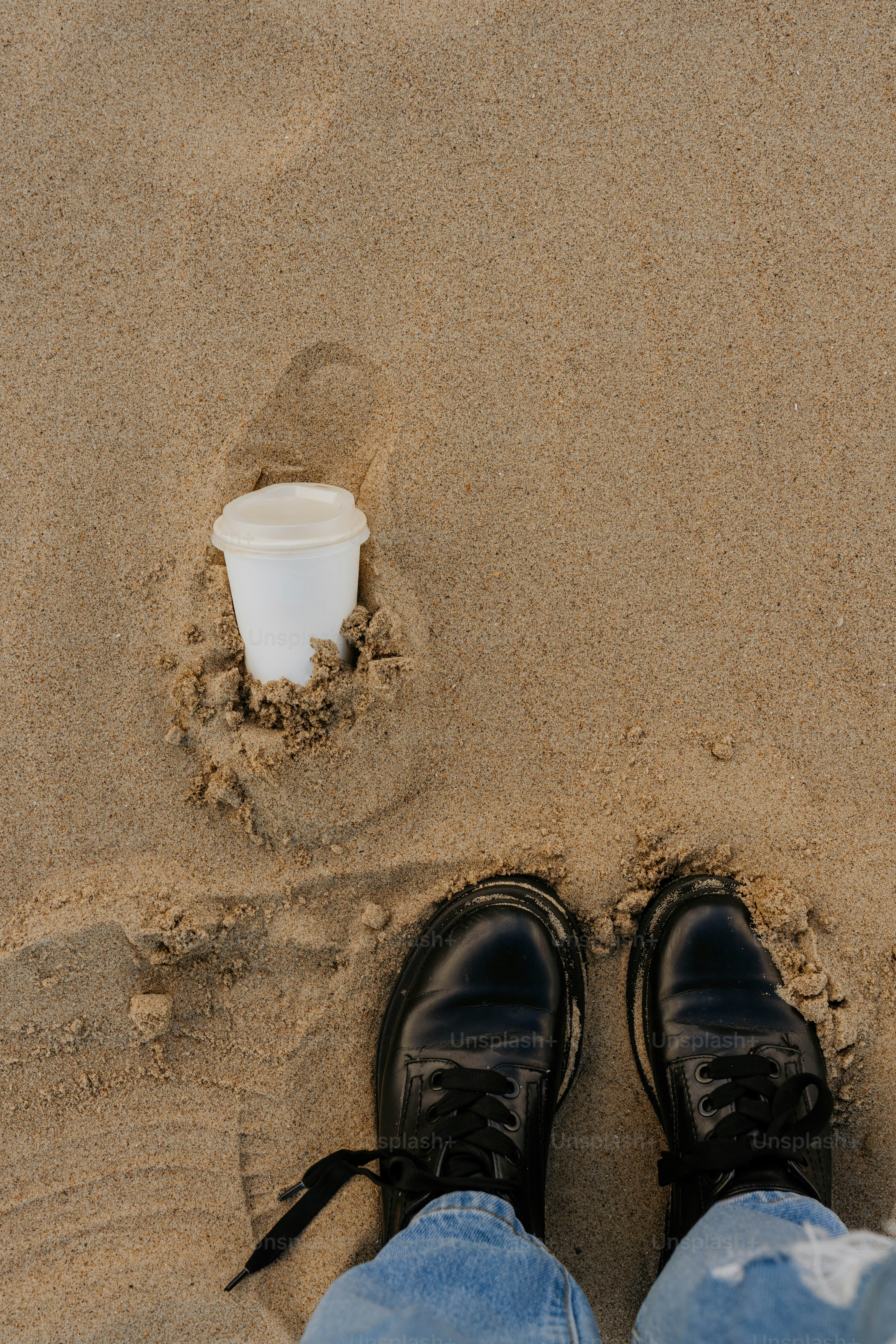 A person standing in the sand with their feet in the sand photo – Flash ...