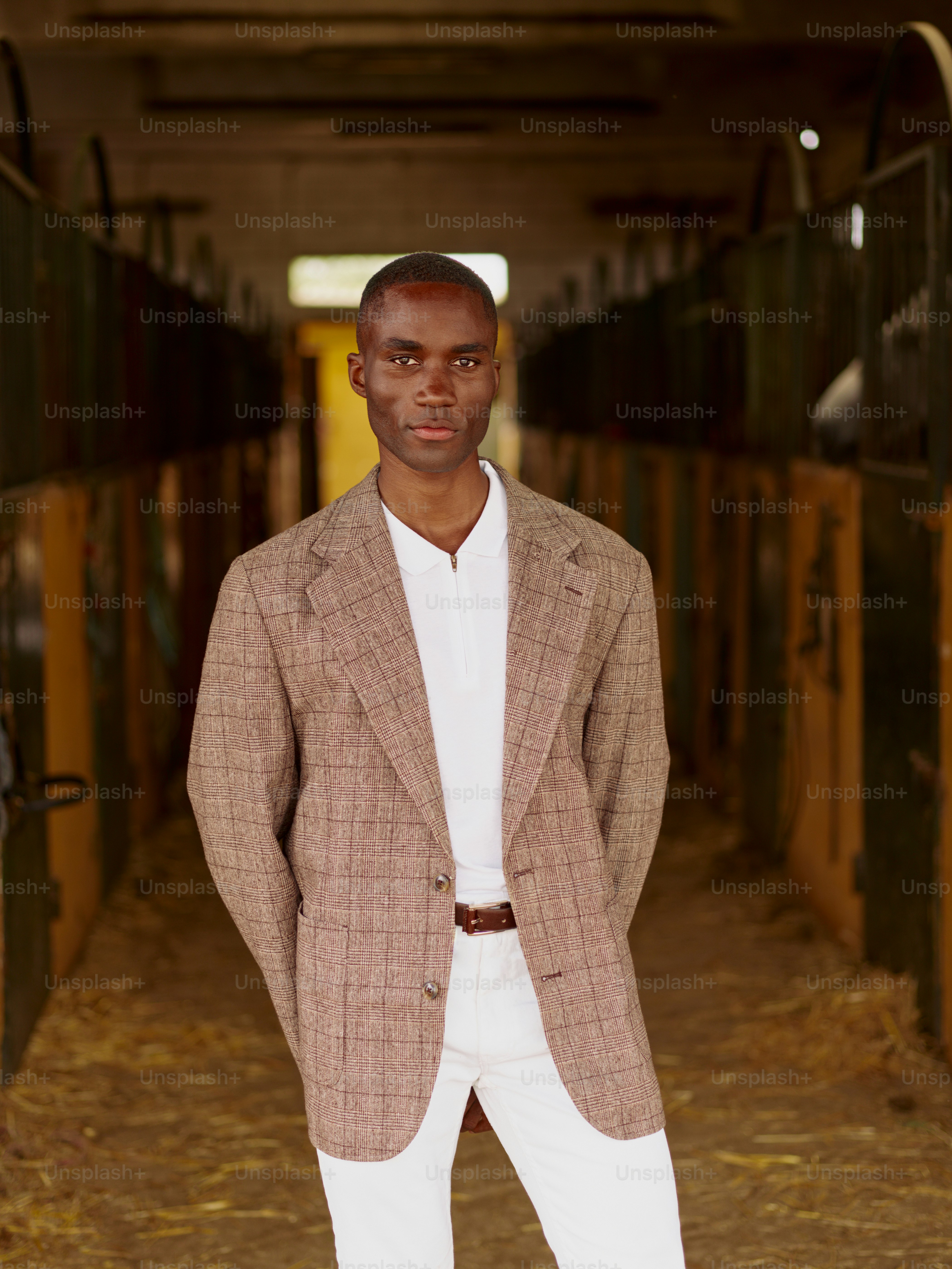 A man standing in a barn with his hands in his pockets photo – Man ...