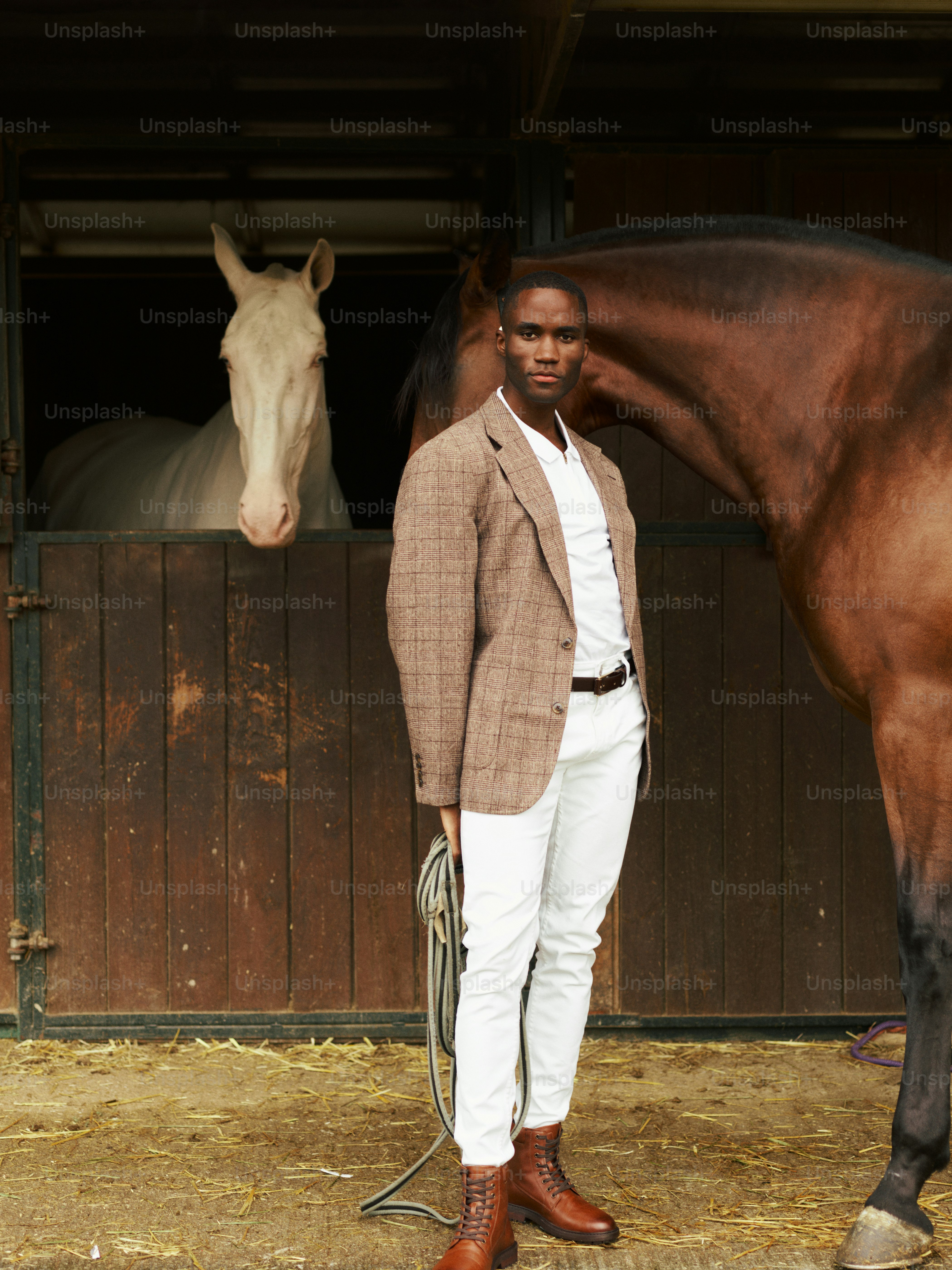 A man standing next to a horse in a stable photo – Old money fashion ...