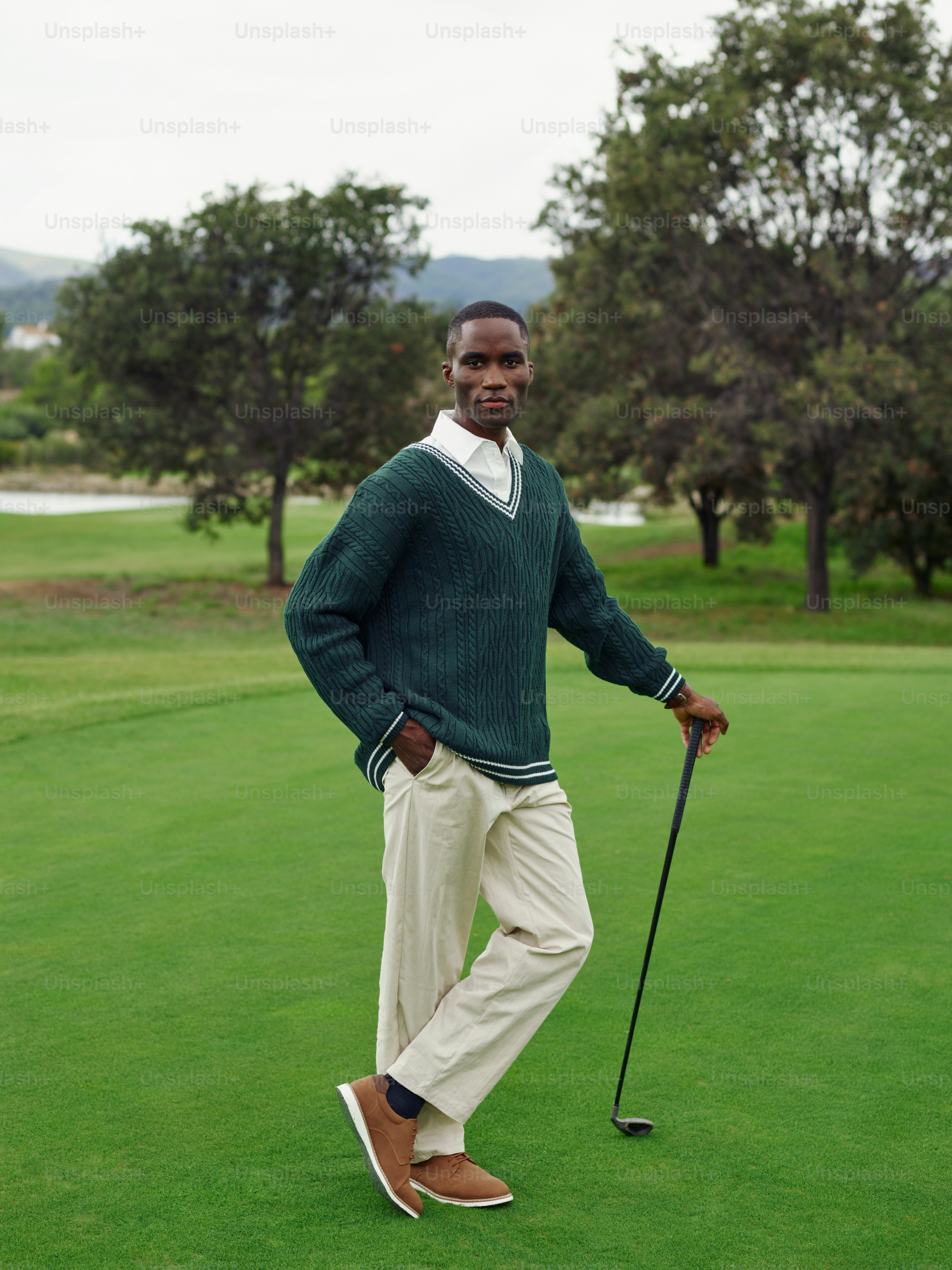 A man standing on a golf green holding a golf club photo – Style Image ...
