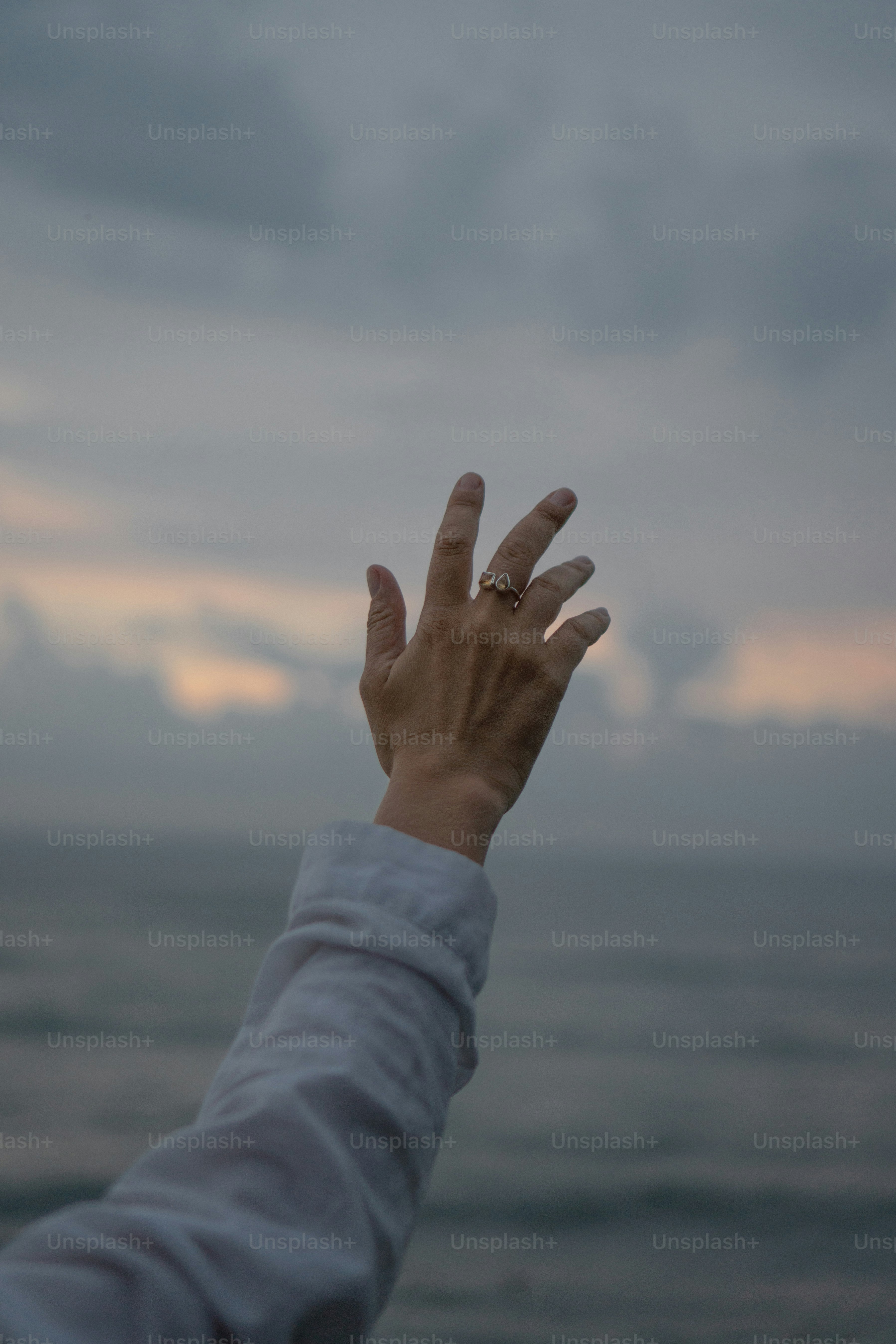 A person reaching up into the sky to catch a frisbee photo – Hands ...